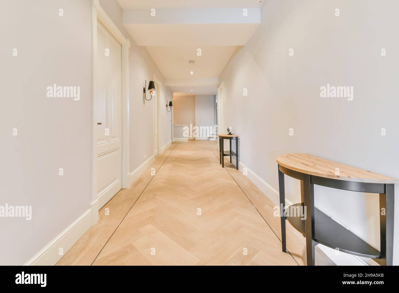 Long stunning hallway with wood flooring and white walls Stock Photo ...