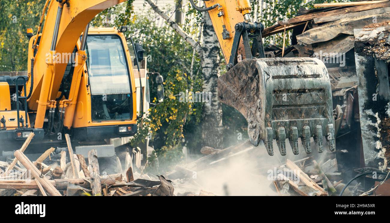 Demolition of old house. Excavator breaks building for new housing ...
