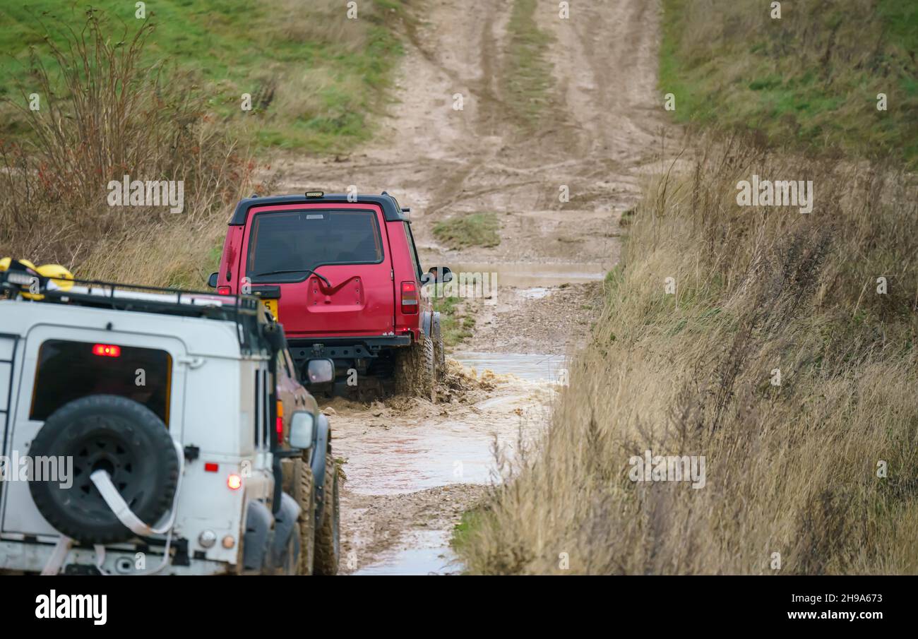 4x4 off-road vehicles driving across mud and water-logged terrain ...