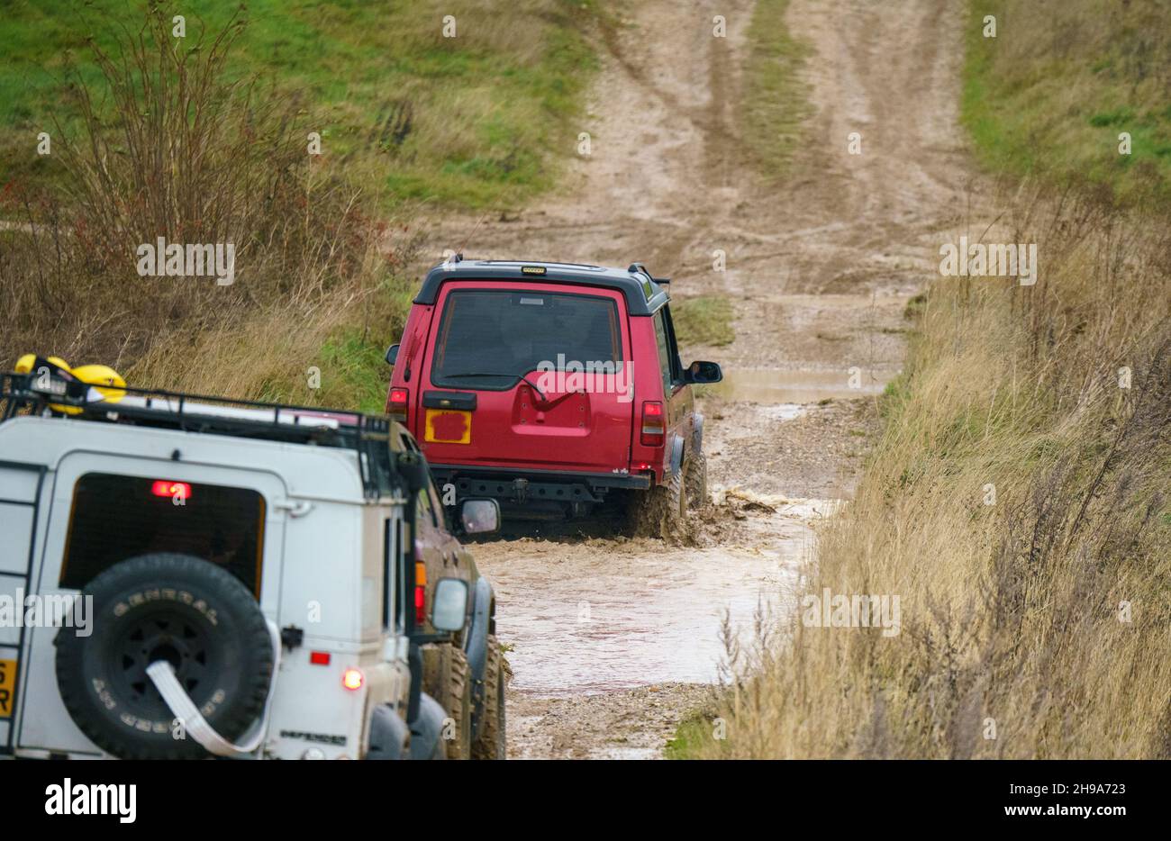 4x4 off-road vehicles driving across mud and water-logged terrain ...