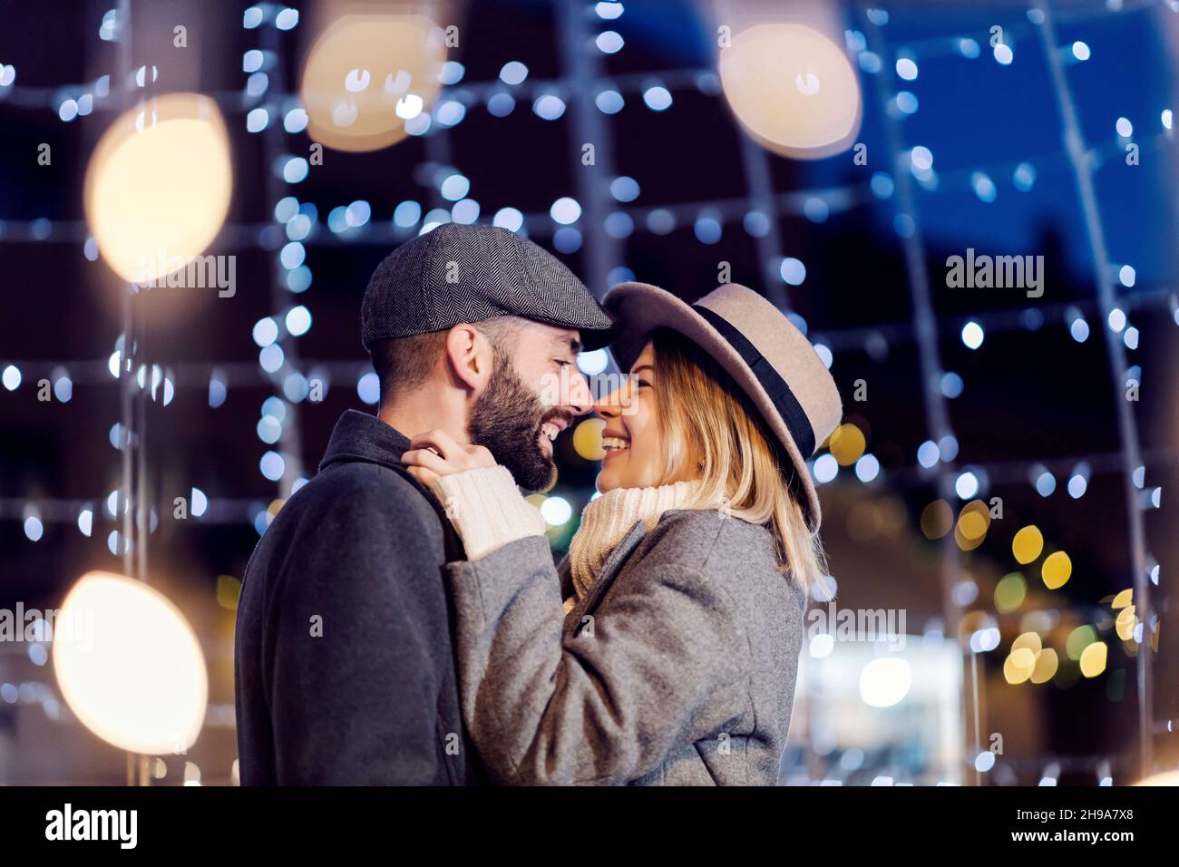 Christmas lovers smiling and hugging on the street on Christmas eve ...