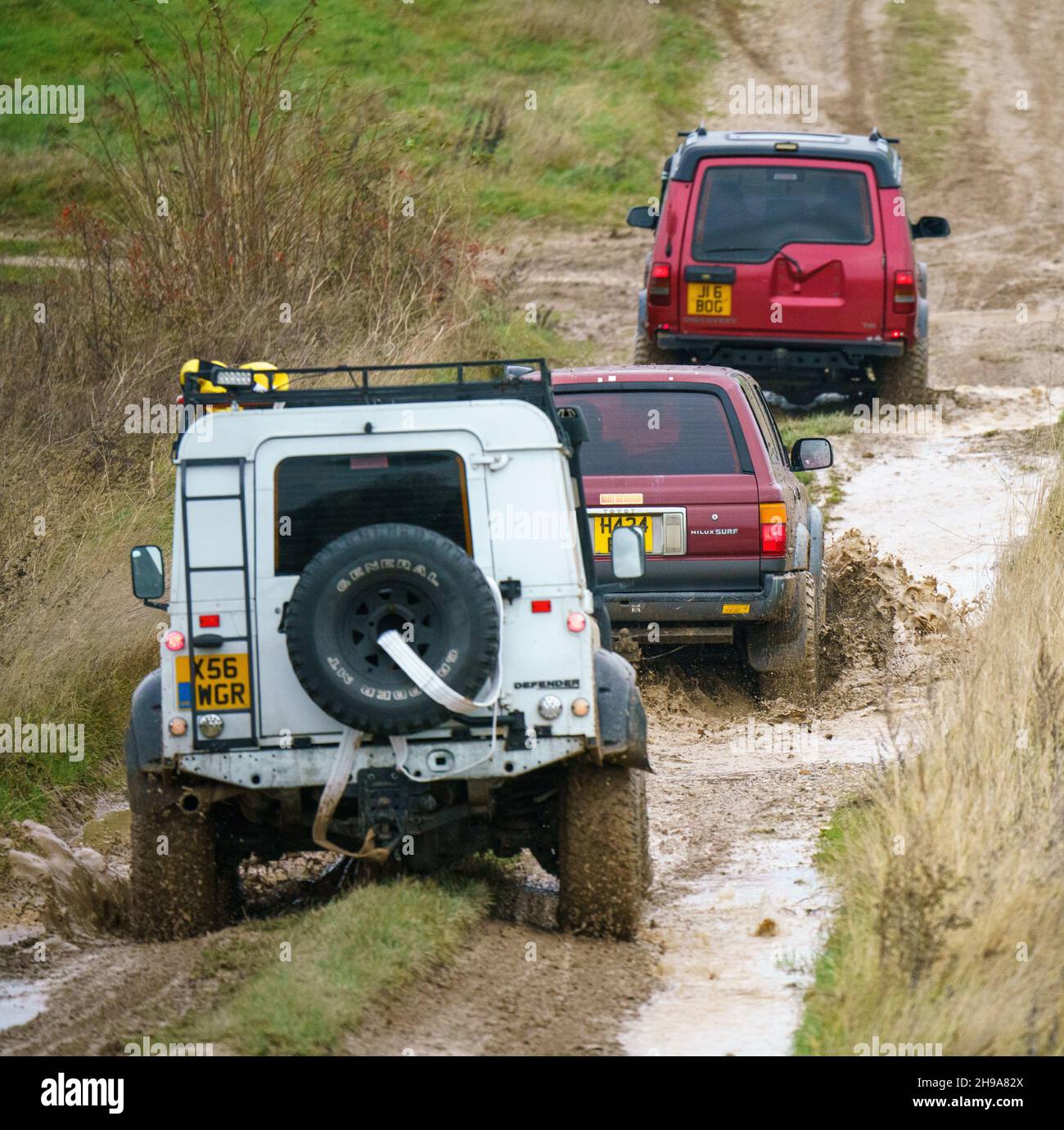 4x4 off-road vehicles driving across mud and water-logged terrain ...