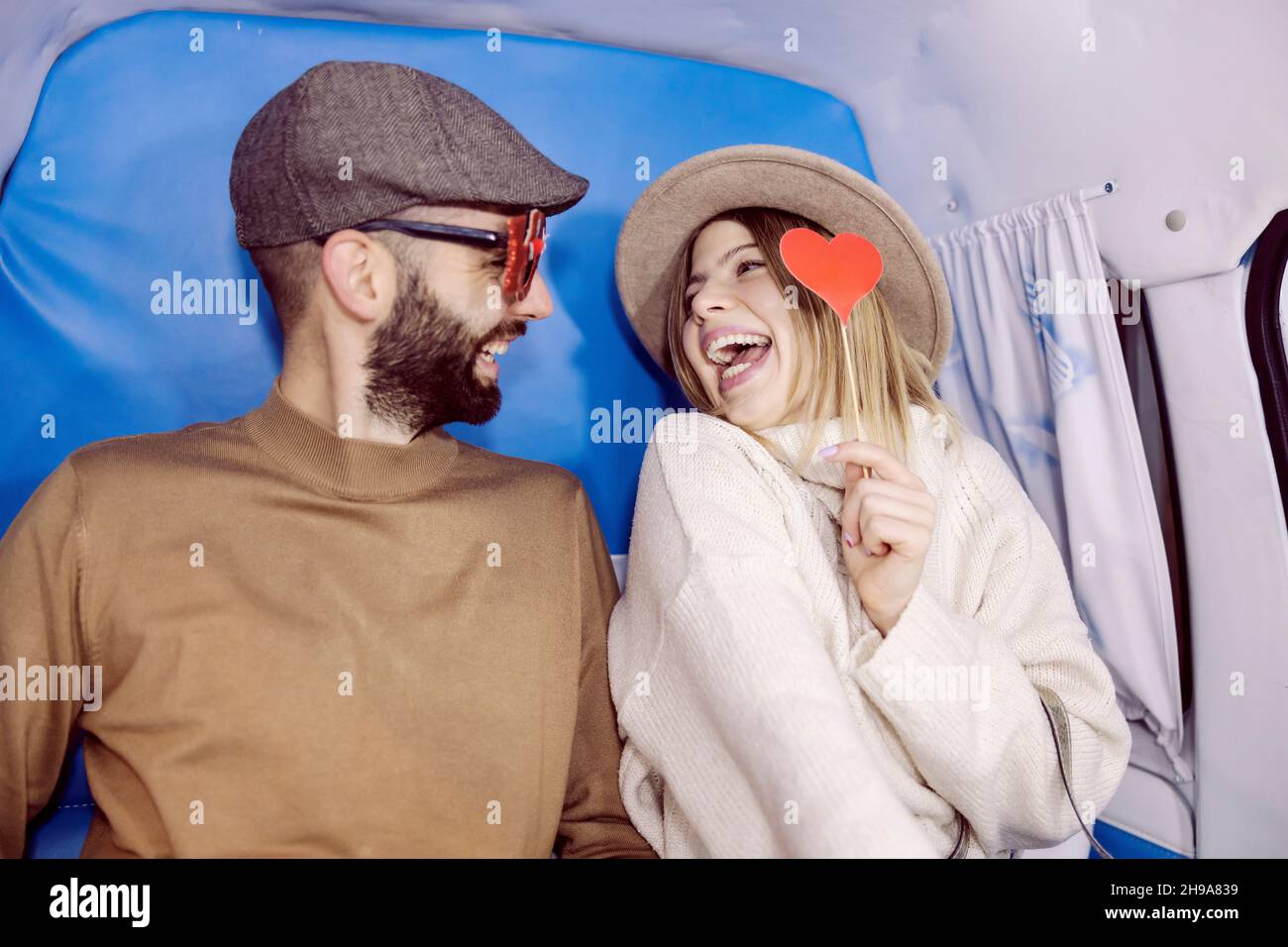 Romantic couple having fun at the photo booth. A young smiling couple ...