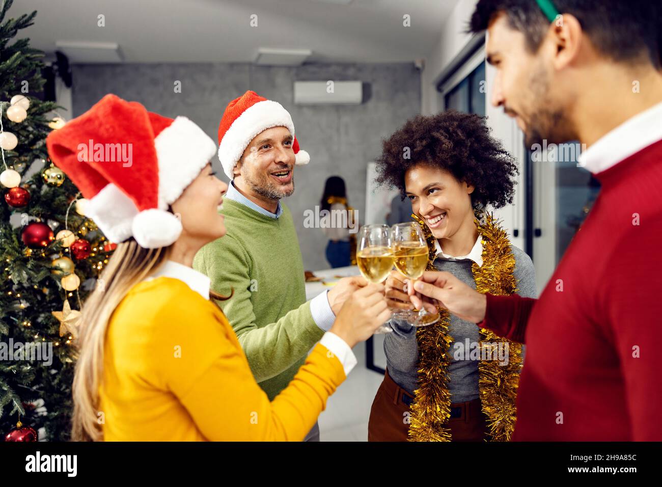 New Year's toast. A small group of multicultural colleagues standing ...