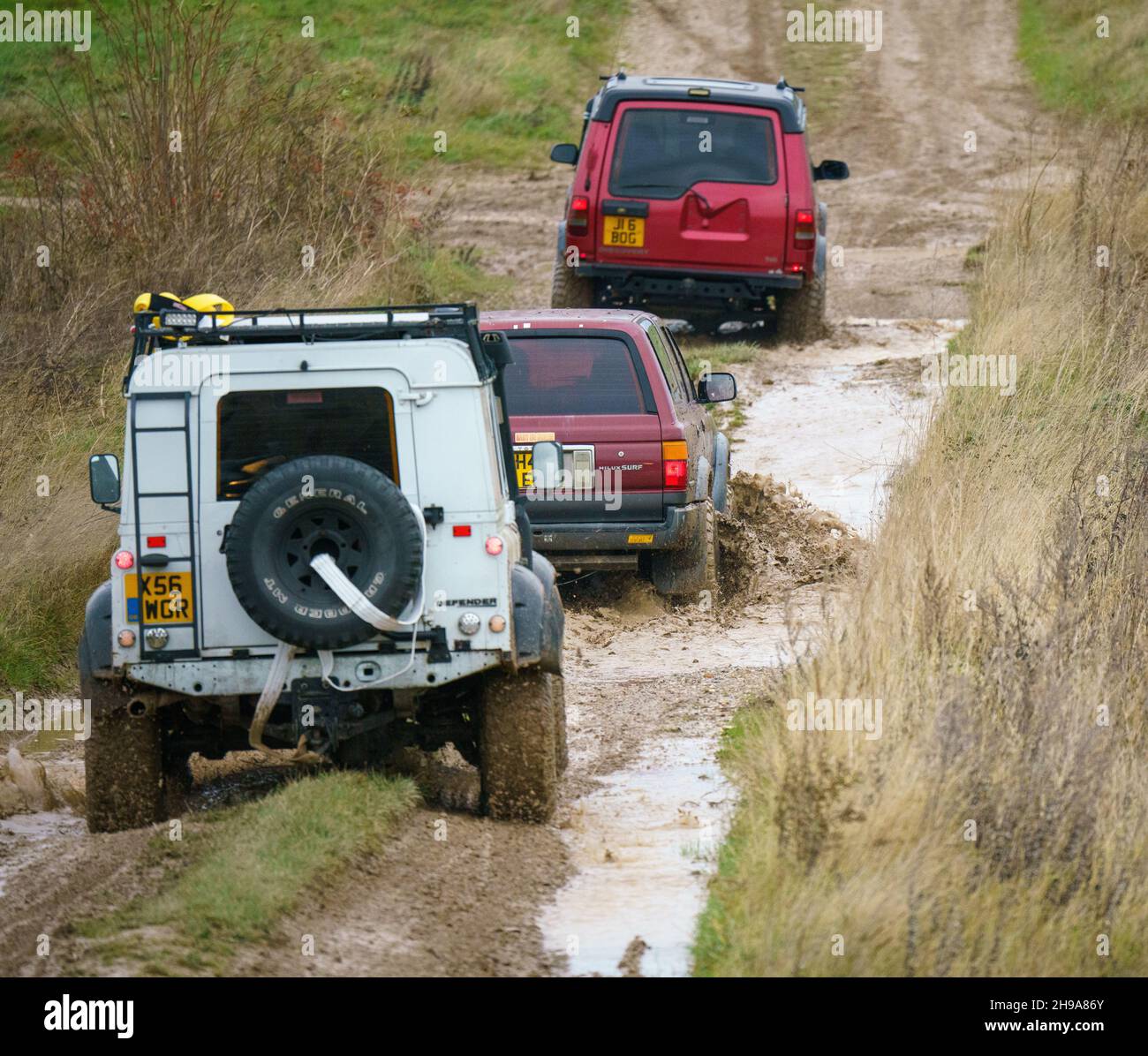 4x4 off-road vehicles driving across mud and water-logged terrain ...