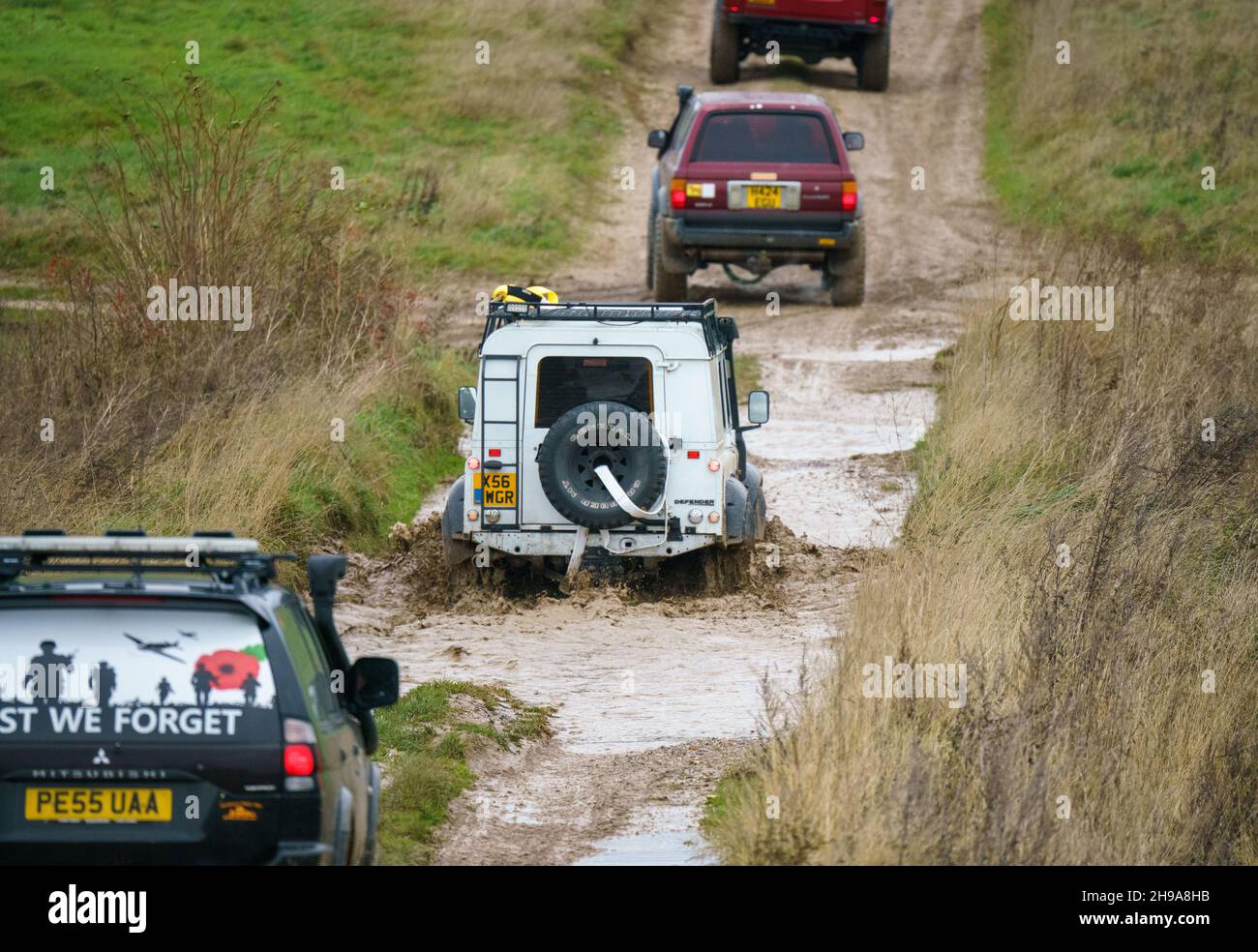 4x4 off-road vehicles driving across mud and water-logged terrain ...