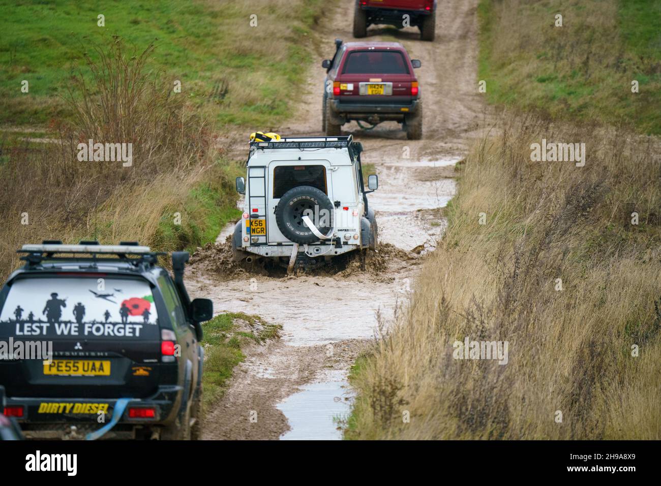 4x4 off-road vehicles driving across mud and water-logged terrain ...