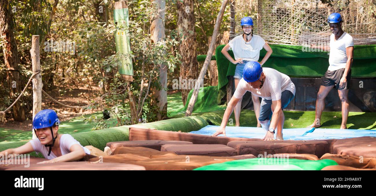 People passing obstacle at adventure park Stock Photo - Alamy