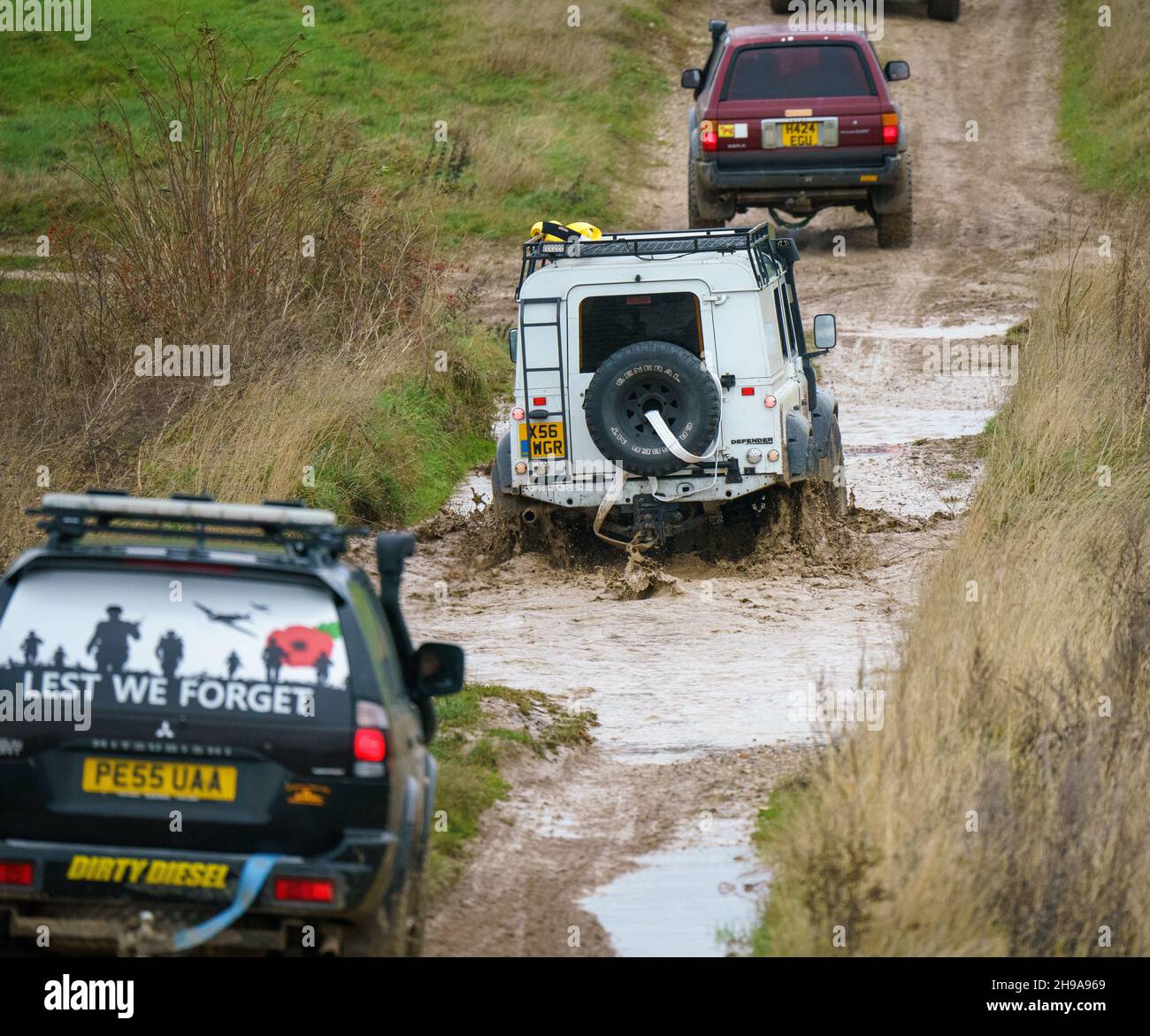 4x4 off-road vehicles driving across mud and water-logged terrain ...
