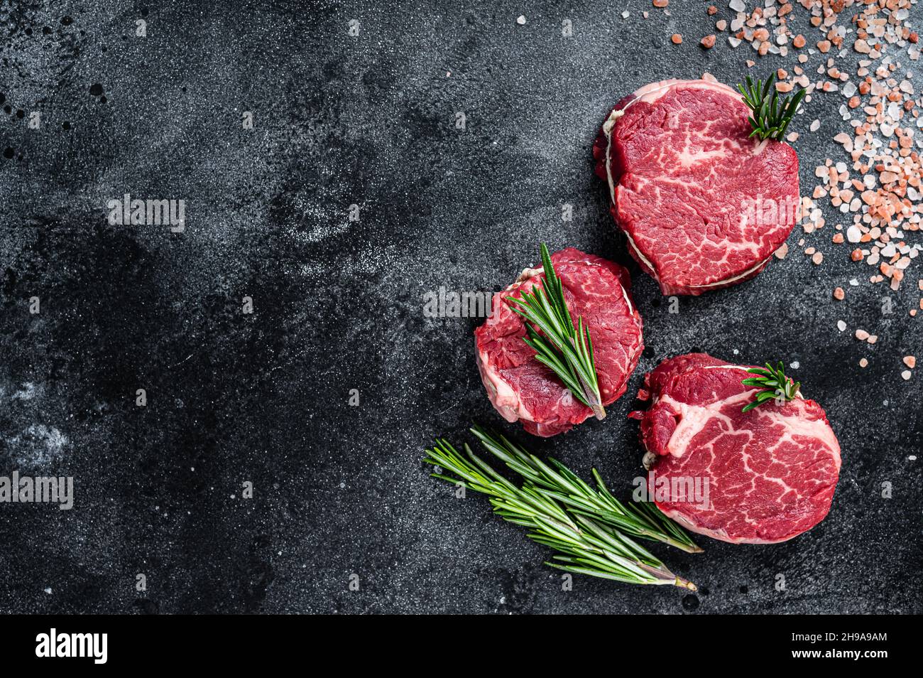 Fillet Mignon tenderloin raw meat beef steaks on butchery table. Black ...