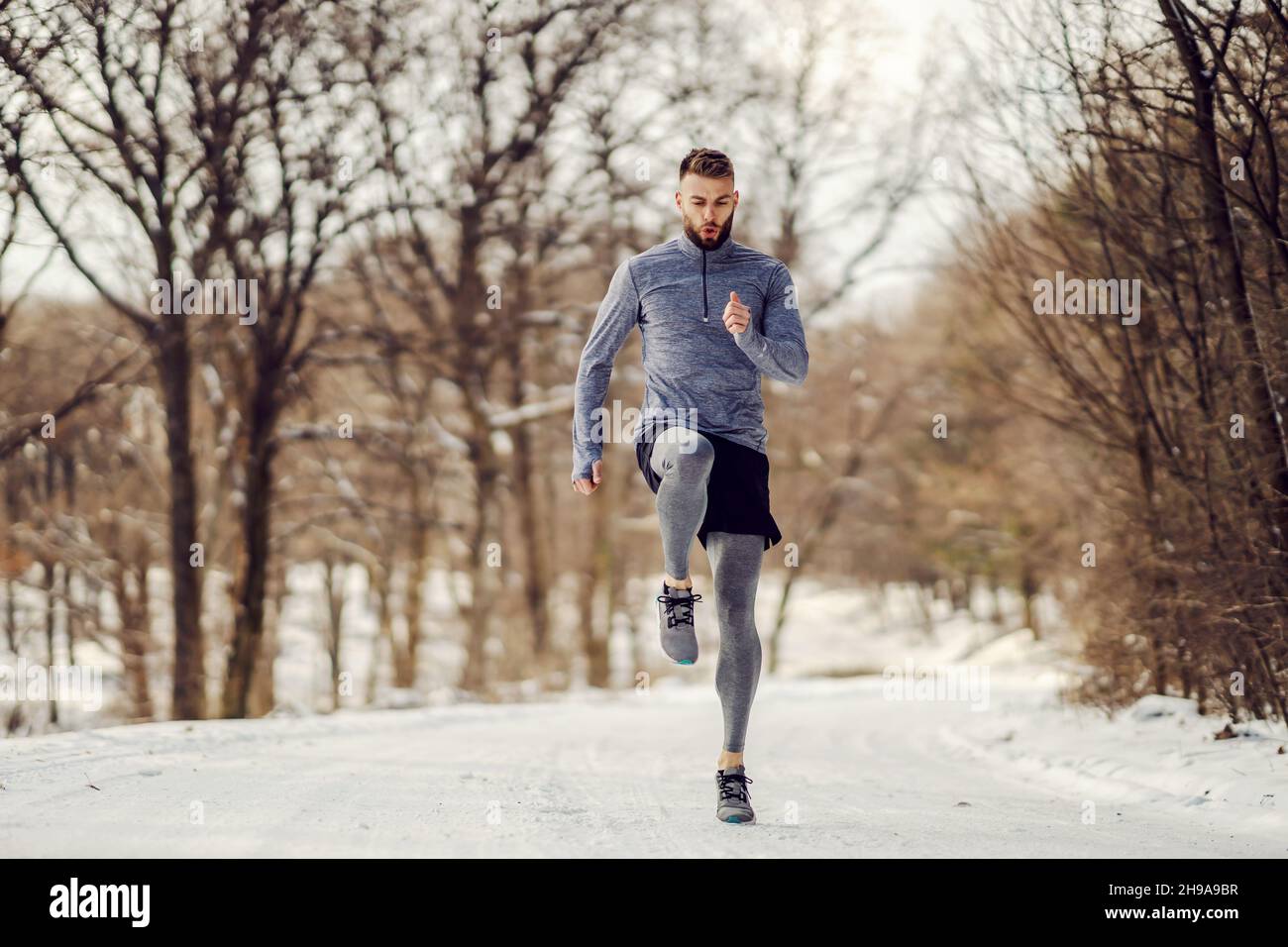 Sportsman running in place in forest at snowy winter day. Winter ...