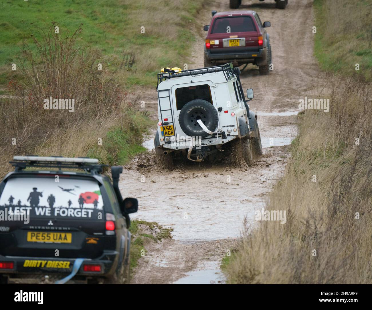 4x4 off-road vehicles driving across mud and water-logged terrain ...