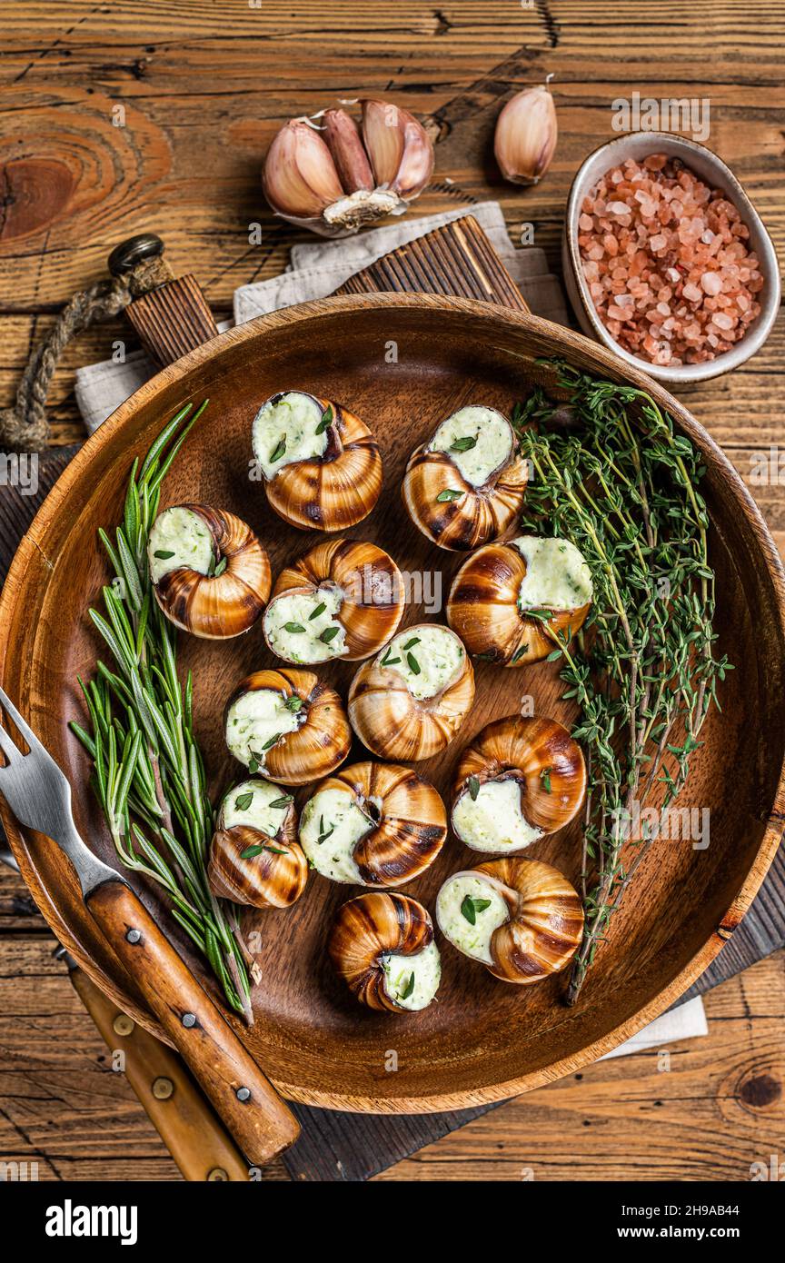 French Escargot Snails with garlic butter in a wooden plate. Wooden ...
