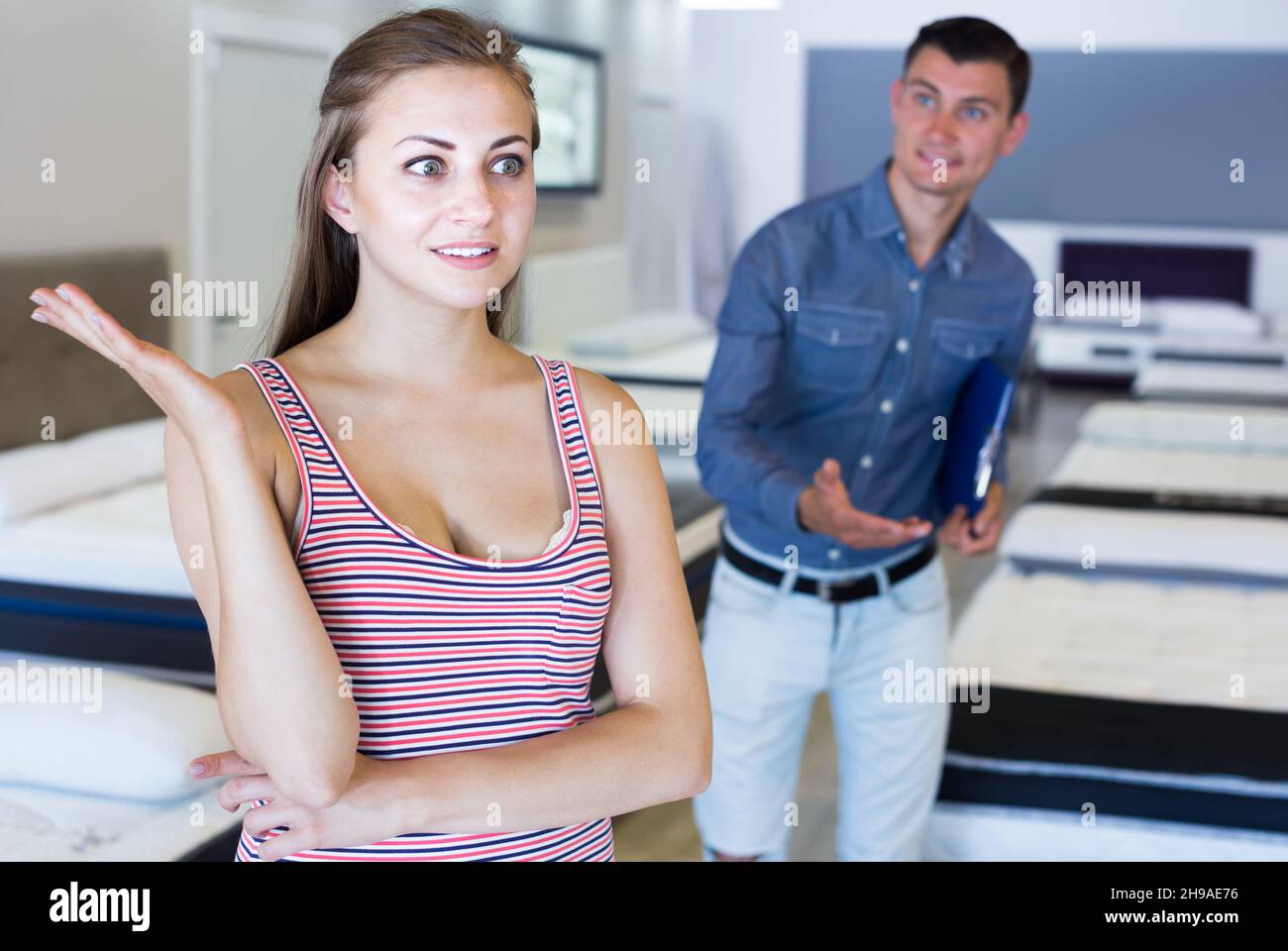 Woman selecting new mattress and store clerk working Stock Photo - Alamy