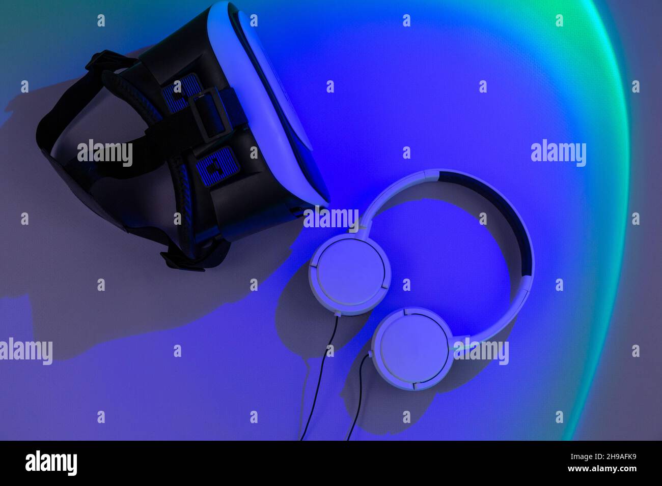 Virtual reality glasses and headphones on the violet background with ...