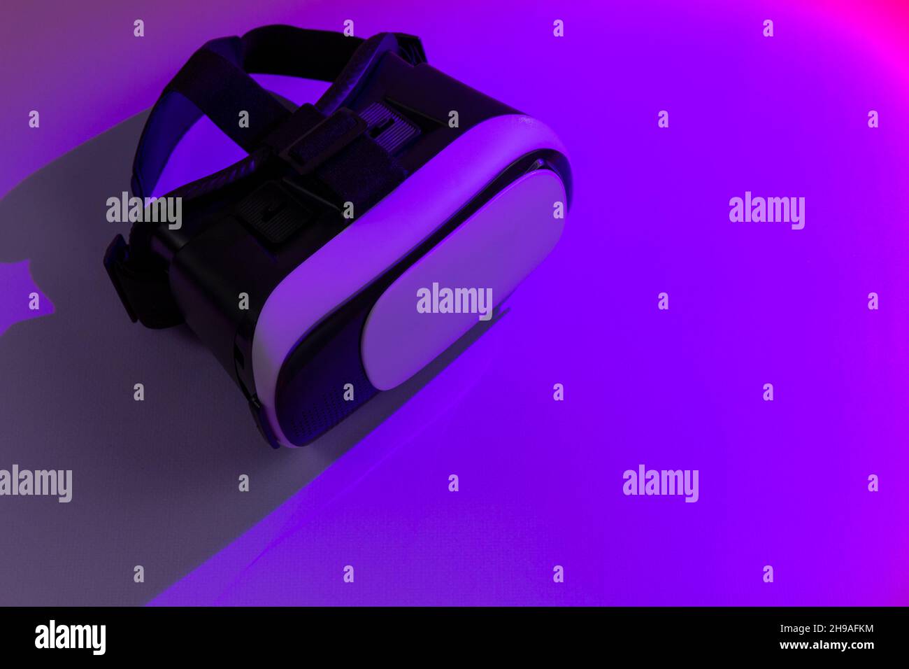 Virtual reality glasses and headphones on the violet background with ...