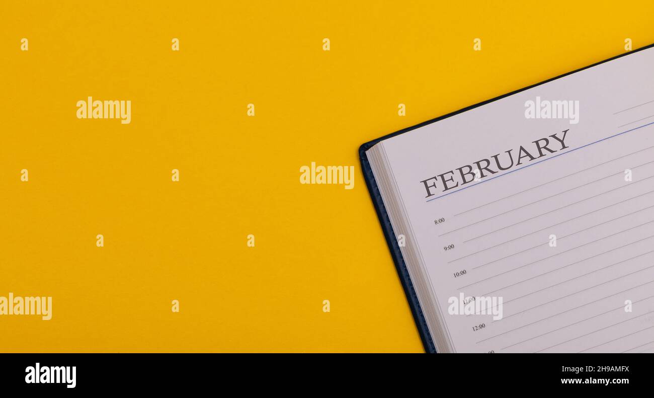 Notepad or diary on a yellow background. Calendar for February. Winter ...