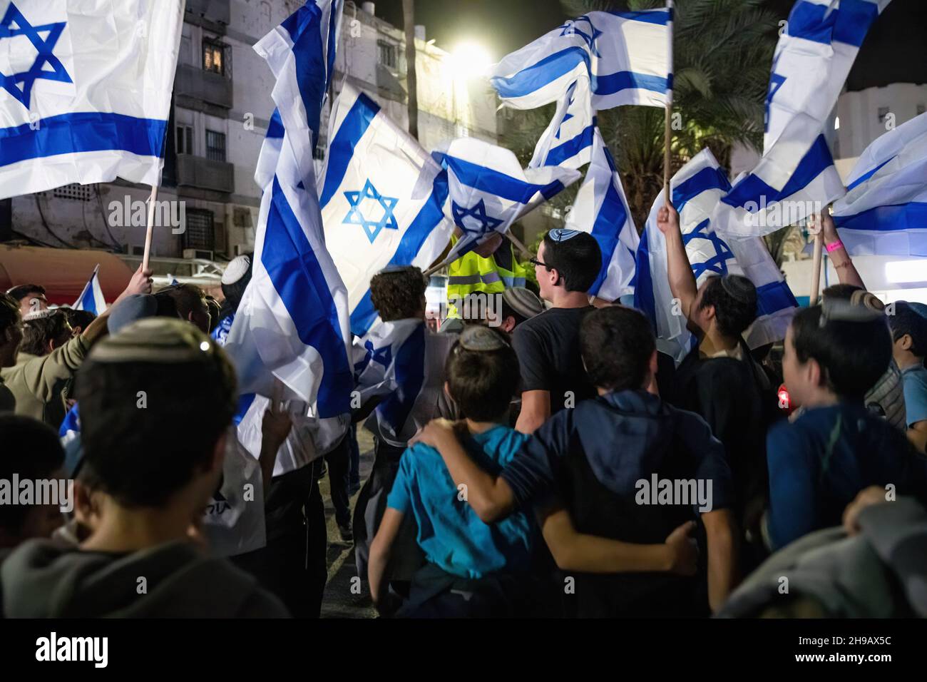 Participants hold flags during the celebrations. Israeli religious ...