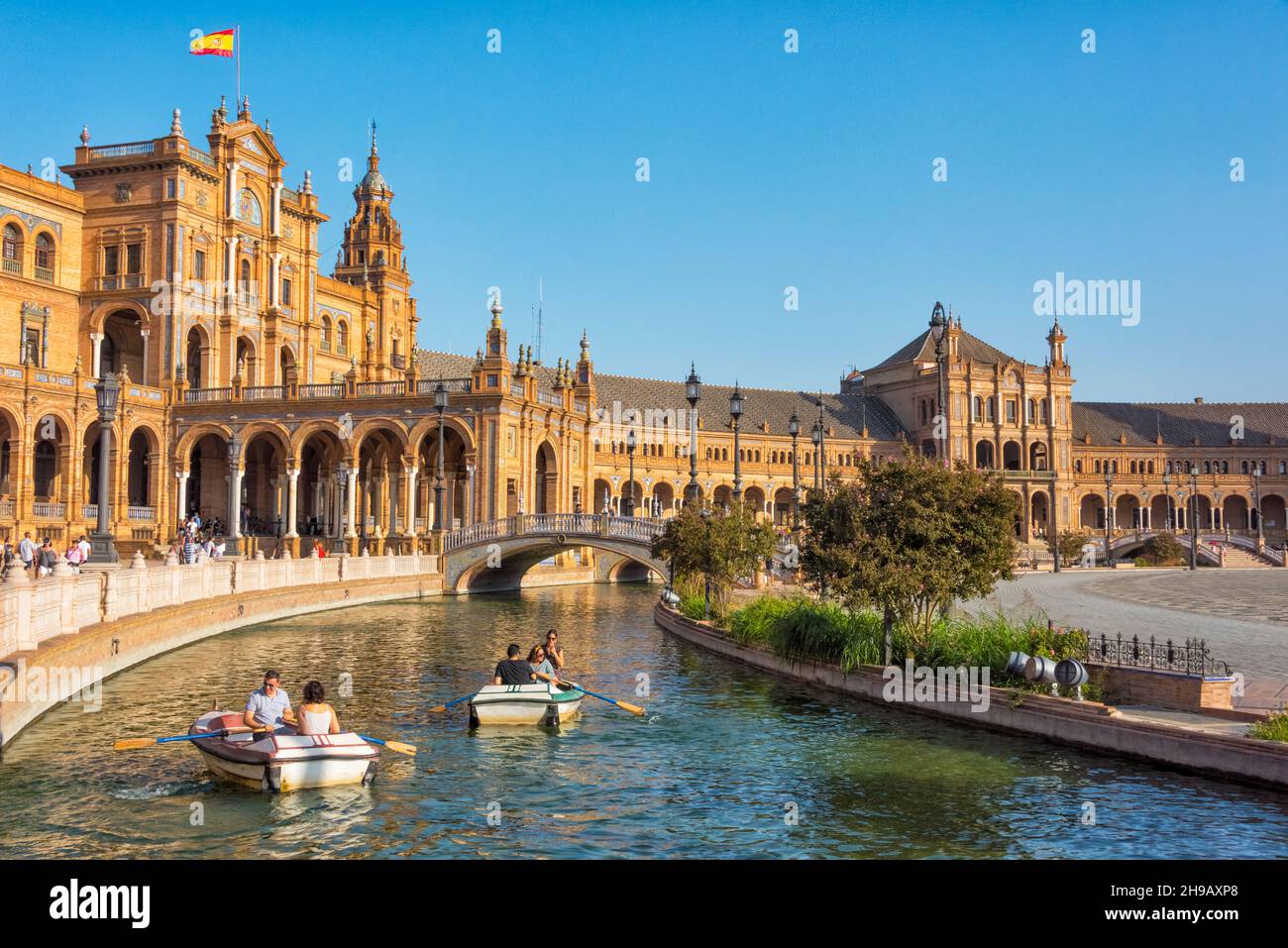 Plaza de Espana, people rowing boat on the moat with bridges ...