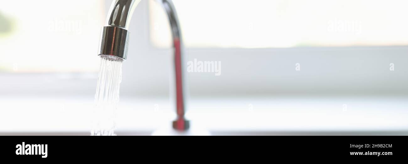 Pure water flows from faucet in kitchen closeup Stock Photo - Alamy