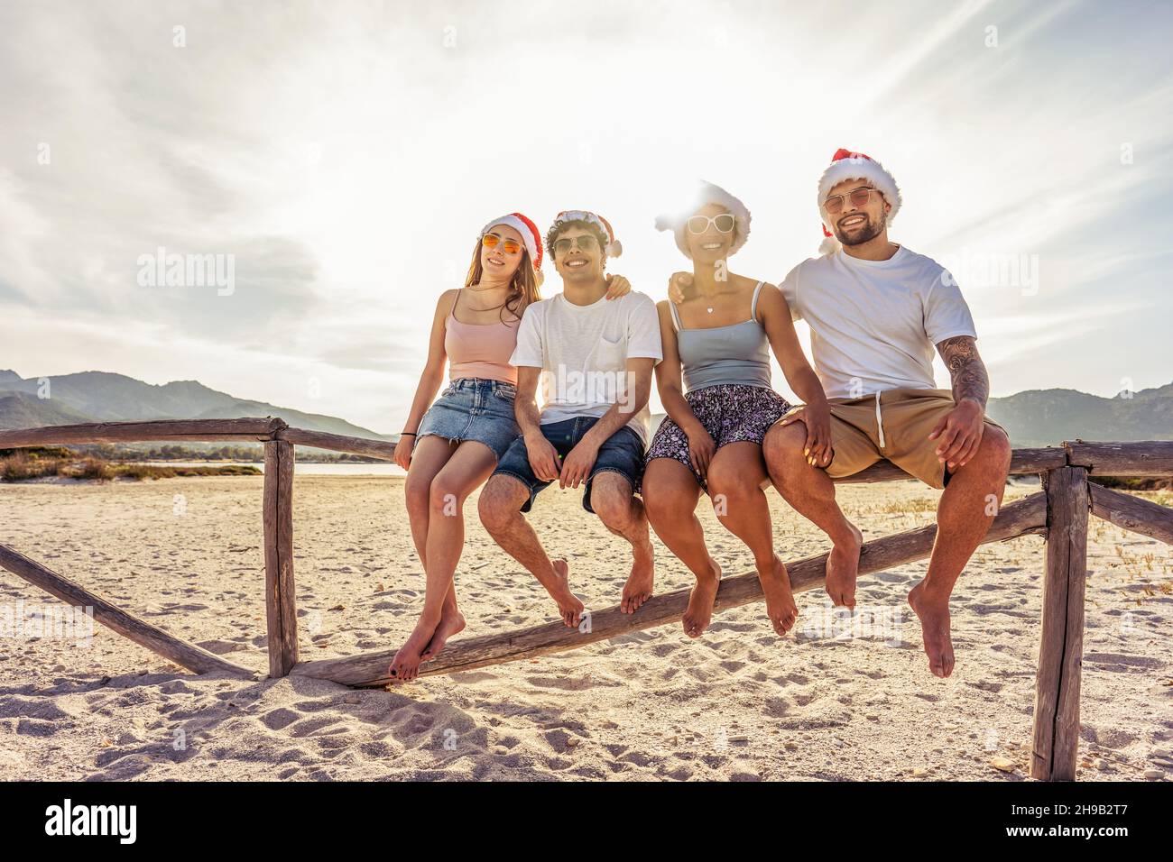 Suggestive photography with backlight sun effect of four young happy ...