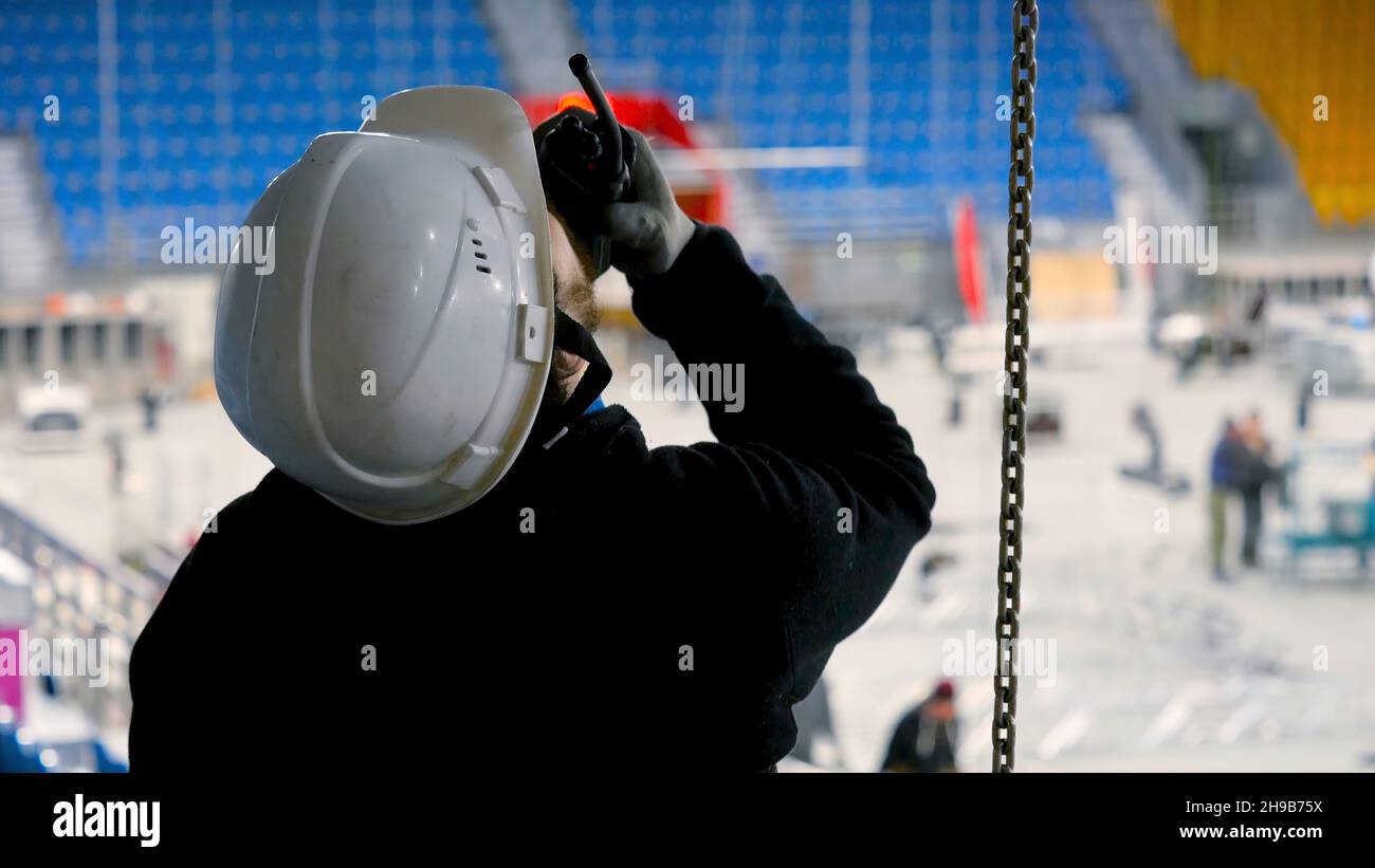 Preparation of stadium with workers. Stock footage. Man in hard hat ...