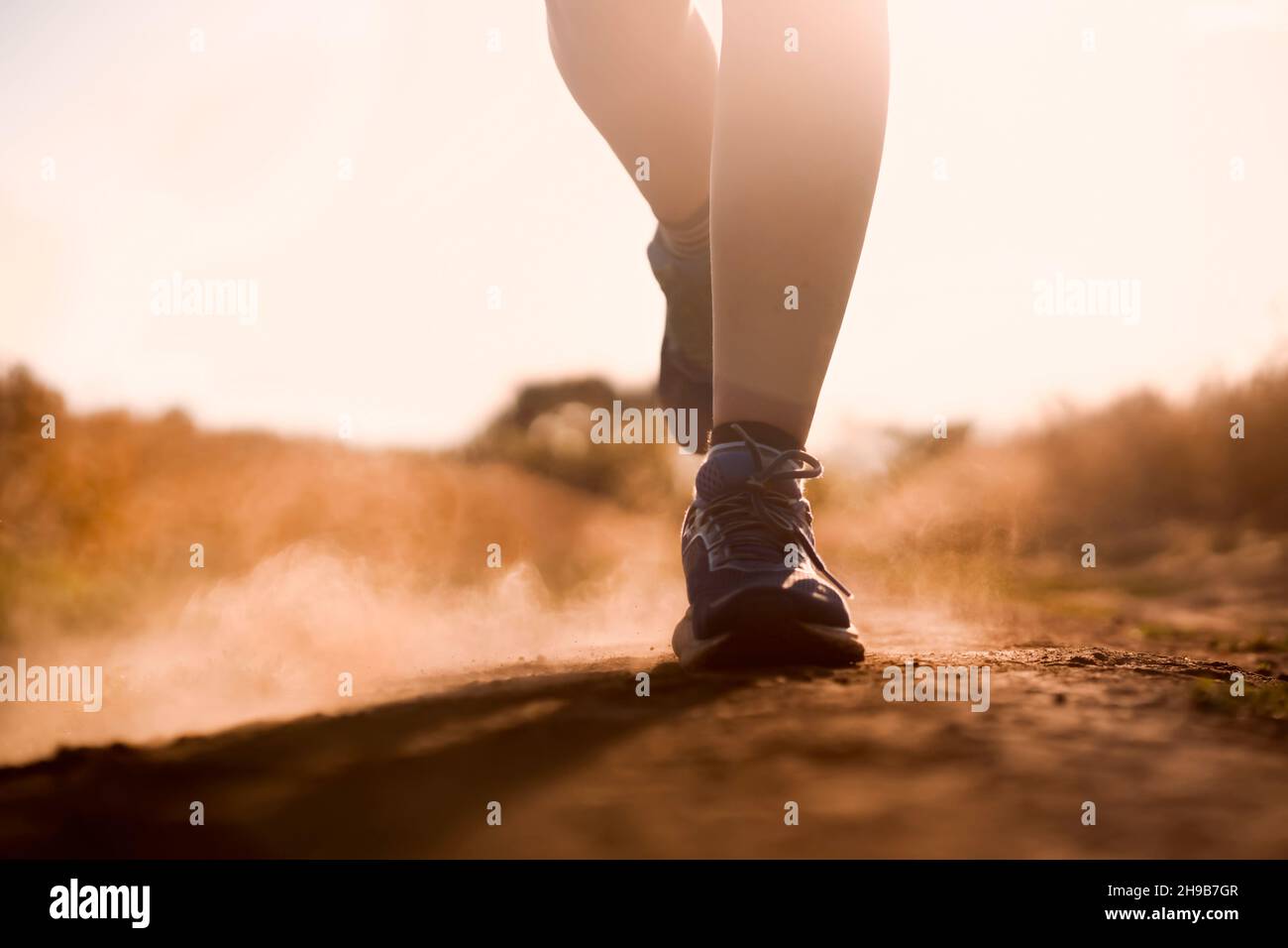 Female athletic legs and dust from the trail close up Stock Photo - Alamy