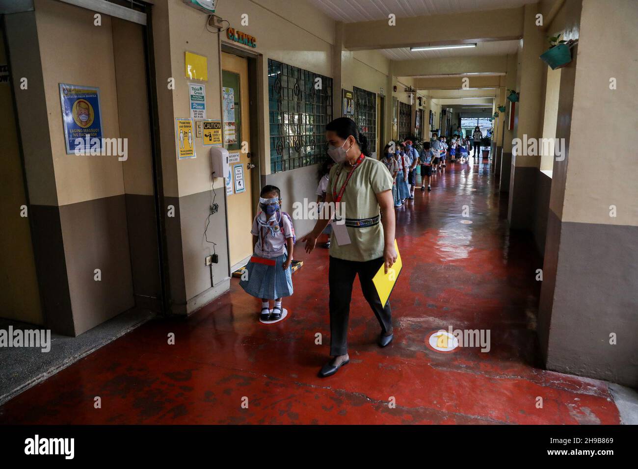 December 6, 2021: A teacher assists students as they queue to attend in ...