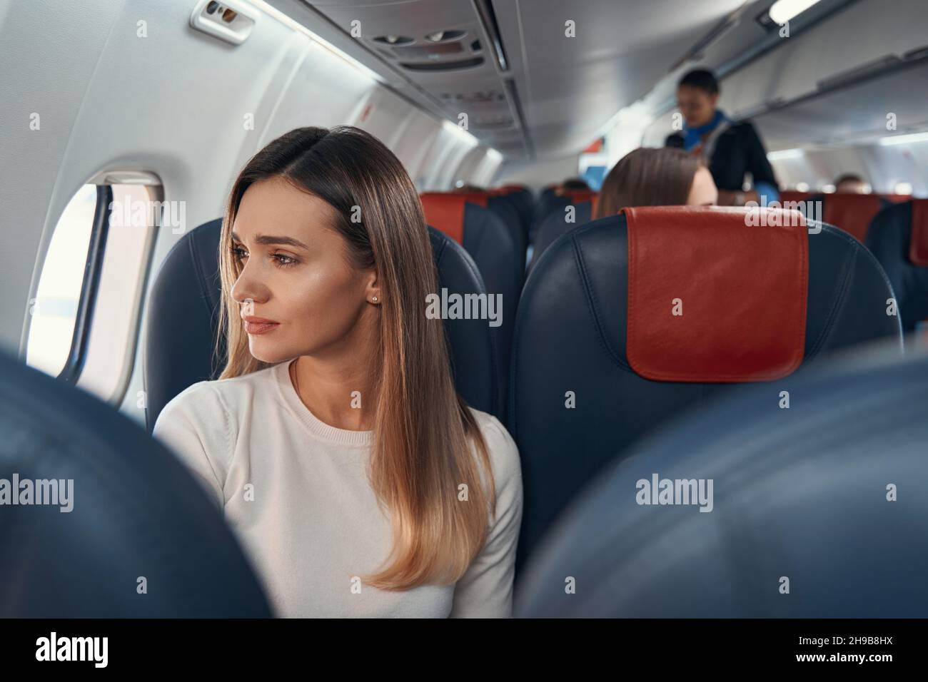 Young passenger looking out of window of plane Stock Photo - Alamy