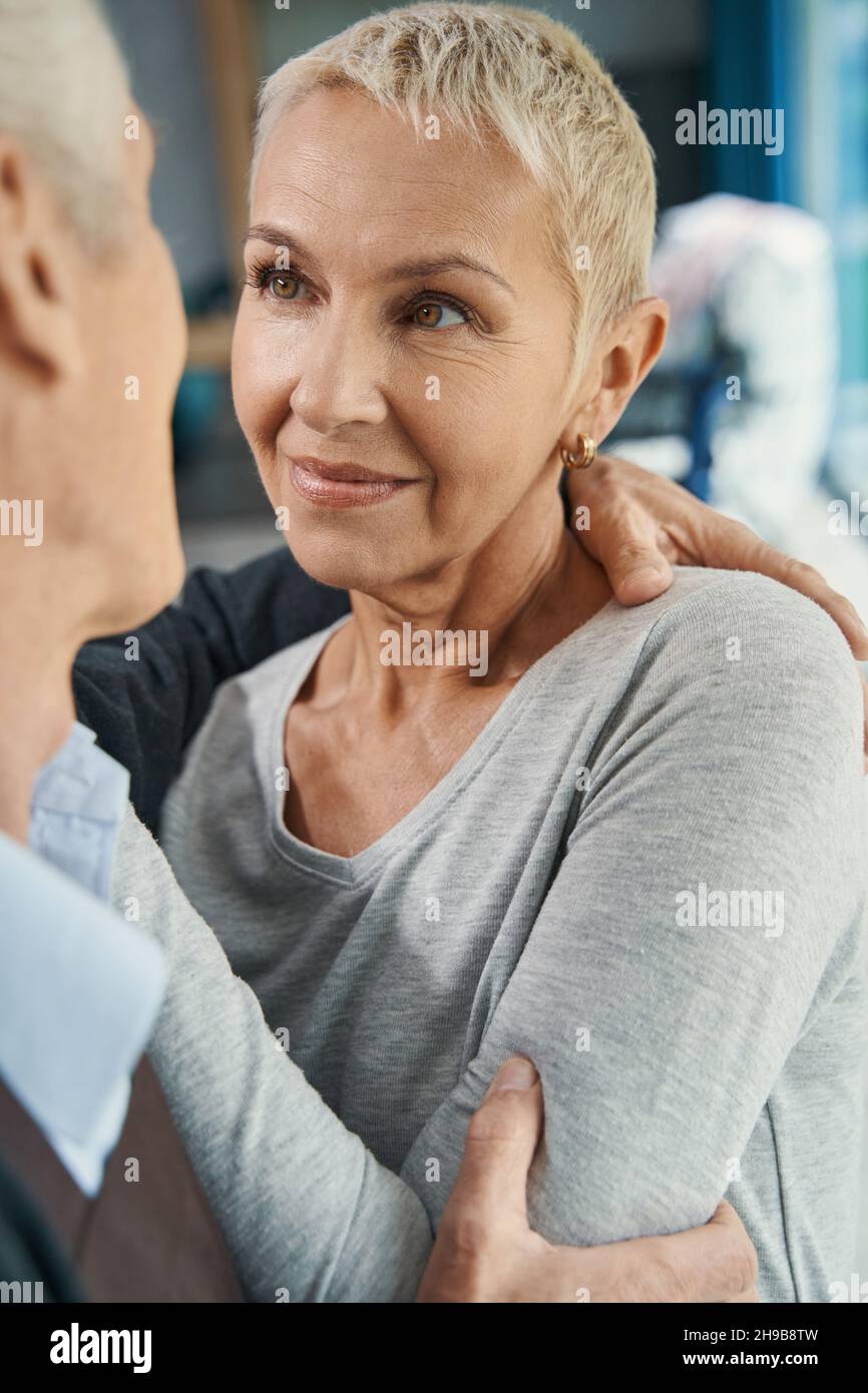 Cheerful aged female person embracing her partner Stock Photo - Alamy