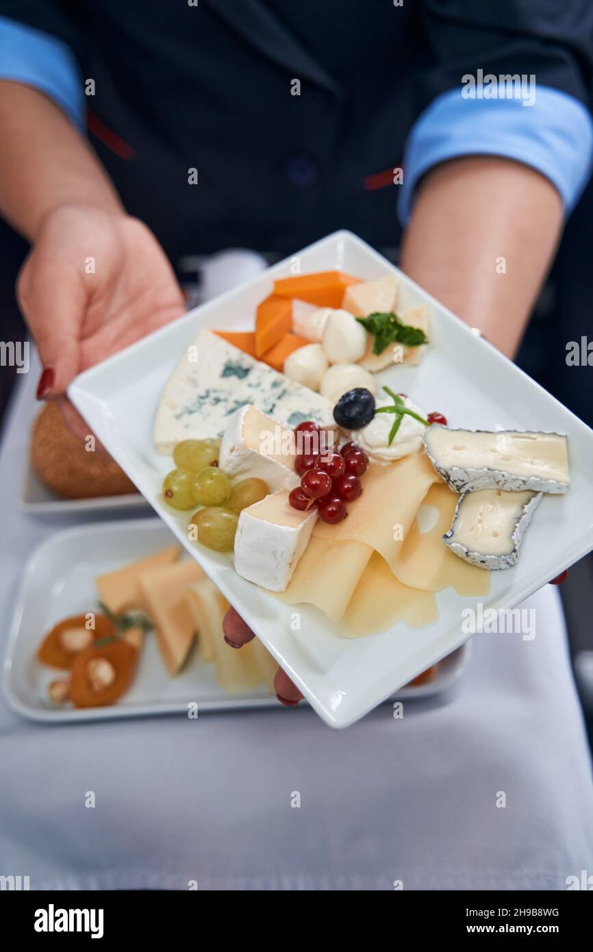 Cabin crew member showing food to camera Stock Photo - Alamy