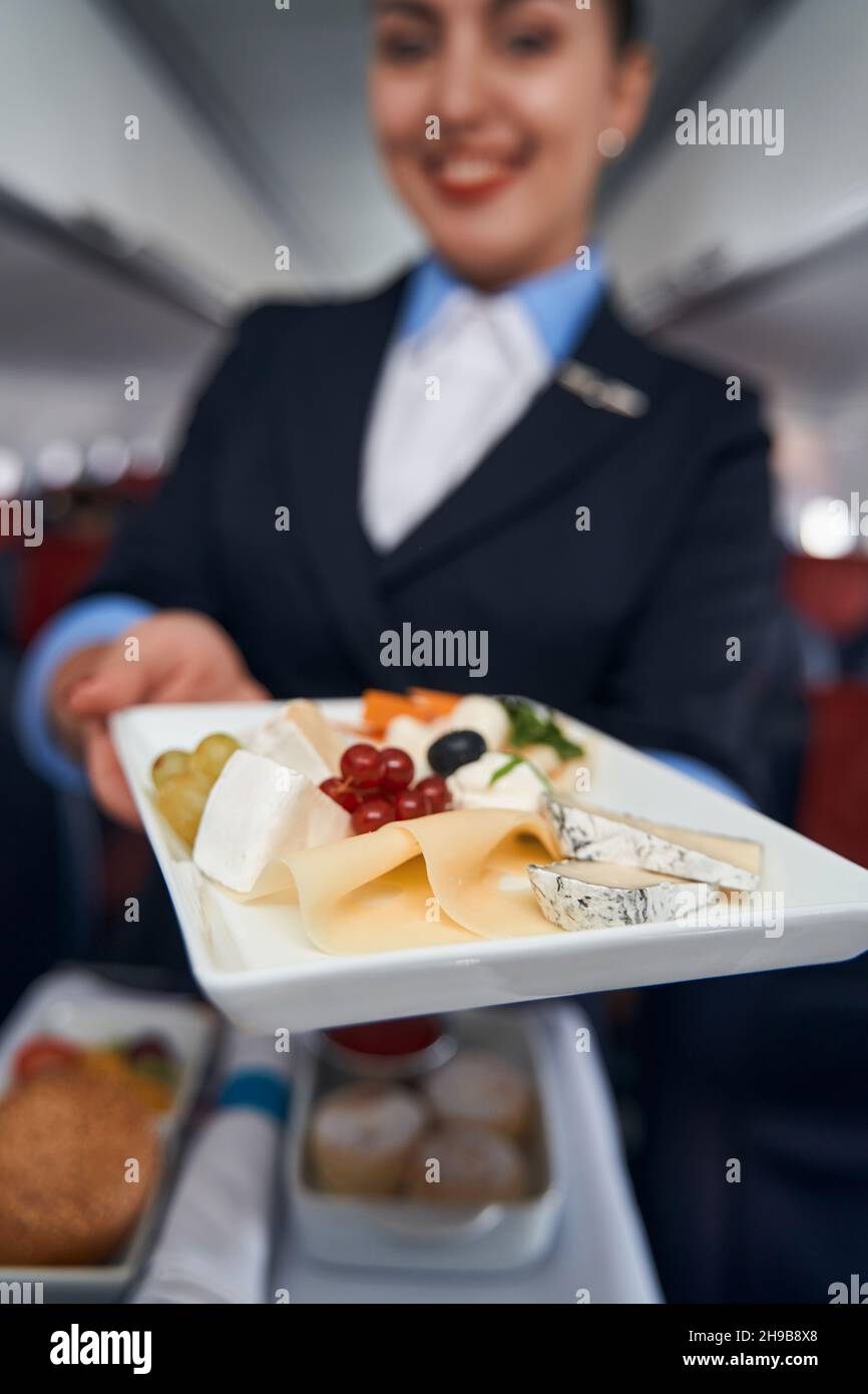 Flight attendant handing out plate with breakfast Stock Photo - Alamy