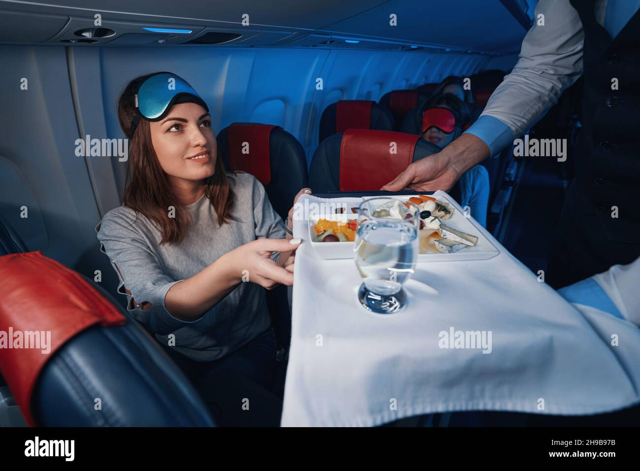 Woman passenger receiving in-flight food from airline steward Stock ...
