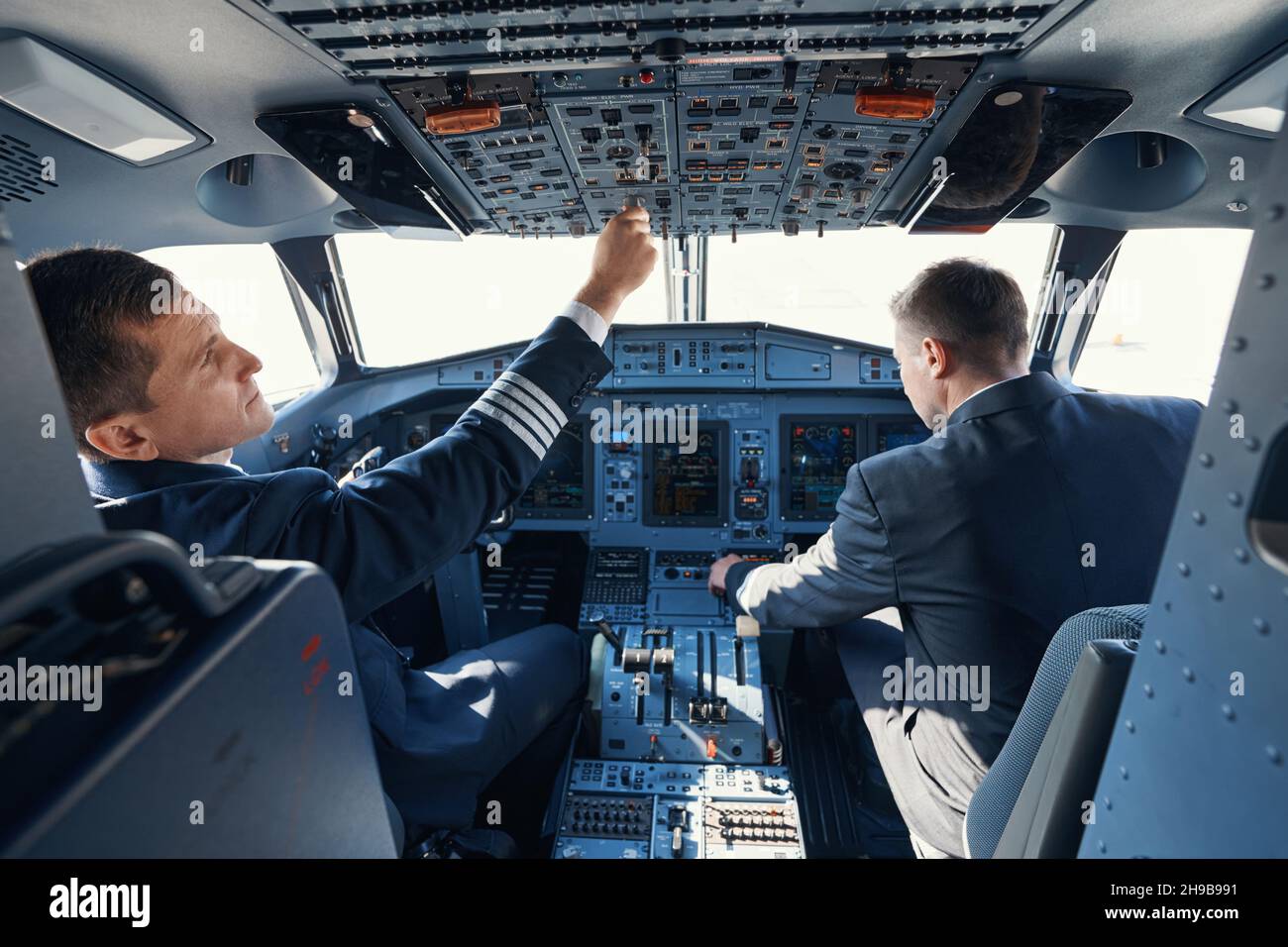 Pair of aircraft pilots toggling switches while taking-off Stock Photo ...