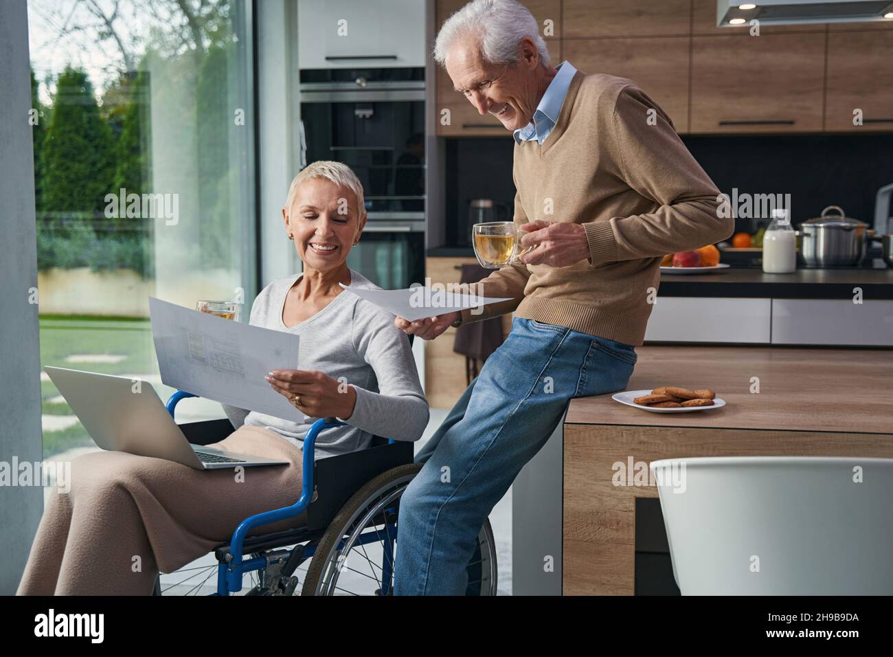 Two happy people drinking tea in the kitchen Stock Photo - Alamy