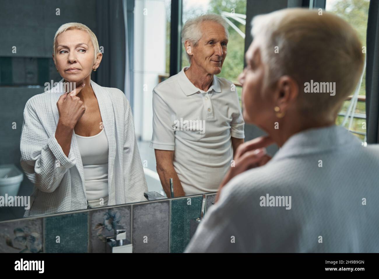 Cute senior woman looking at her reflection Stock Photo - Alamy