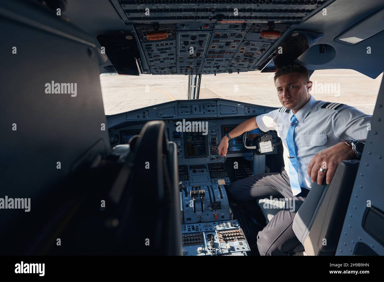 Aircraft pilot sitting sideways in cockpit and looking in the direction ...