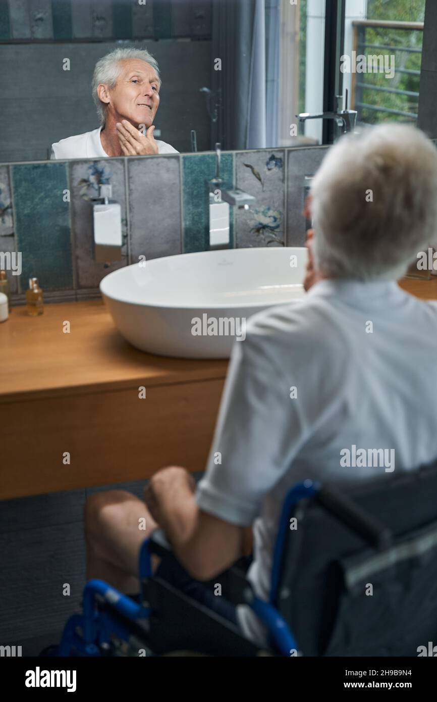 Disabled male person looking at his reflection Stock Photo - Alamy