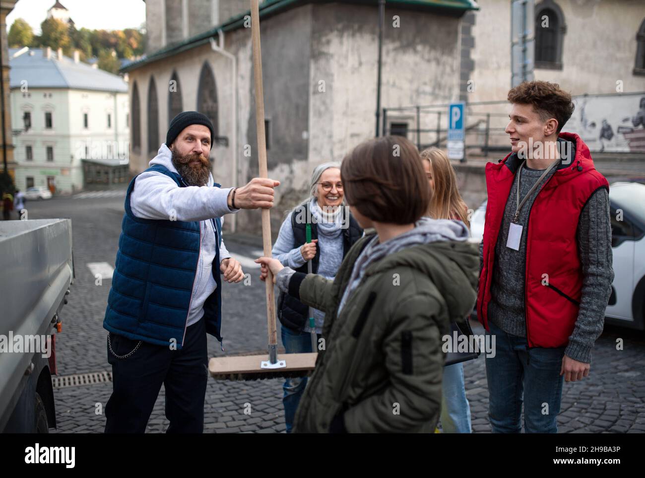Group of happy volunteers talking and ready to clean up street ...