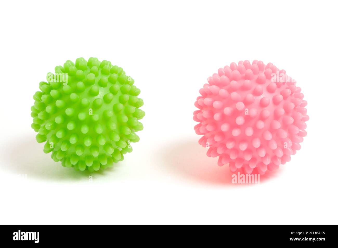 Two prickly plastic balls green and pink on white background Stock ...