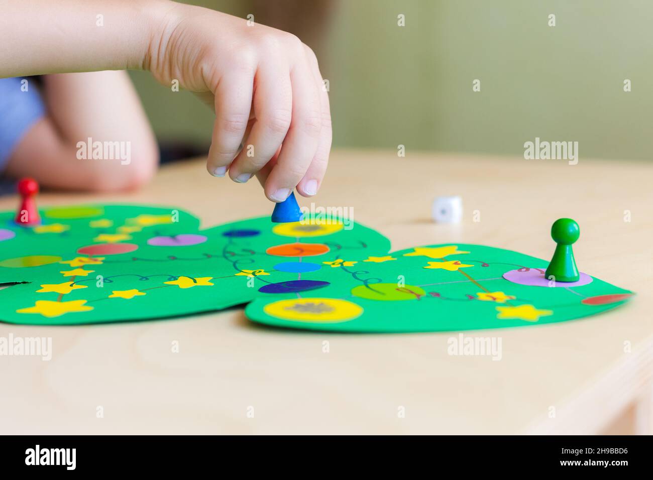 child hand rolls the dice and moves the chip across the Christmas ...