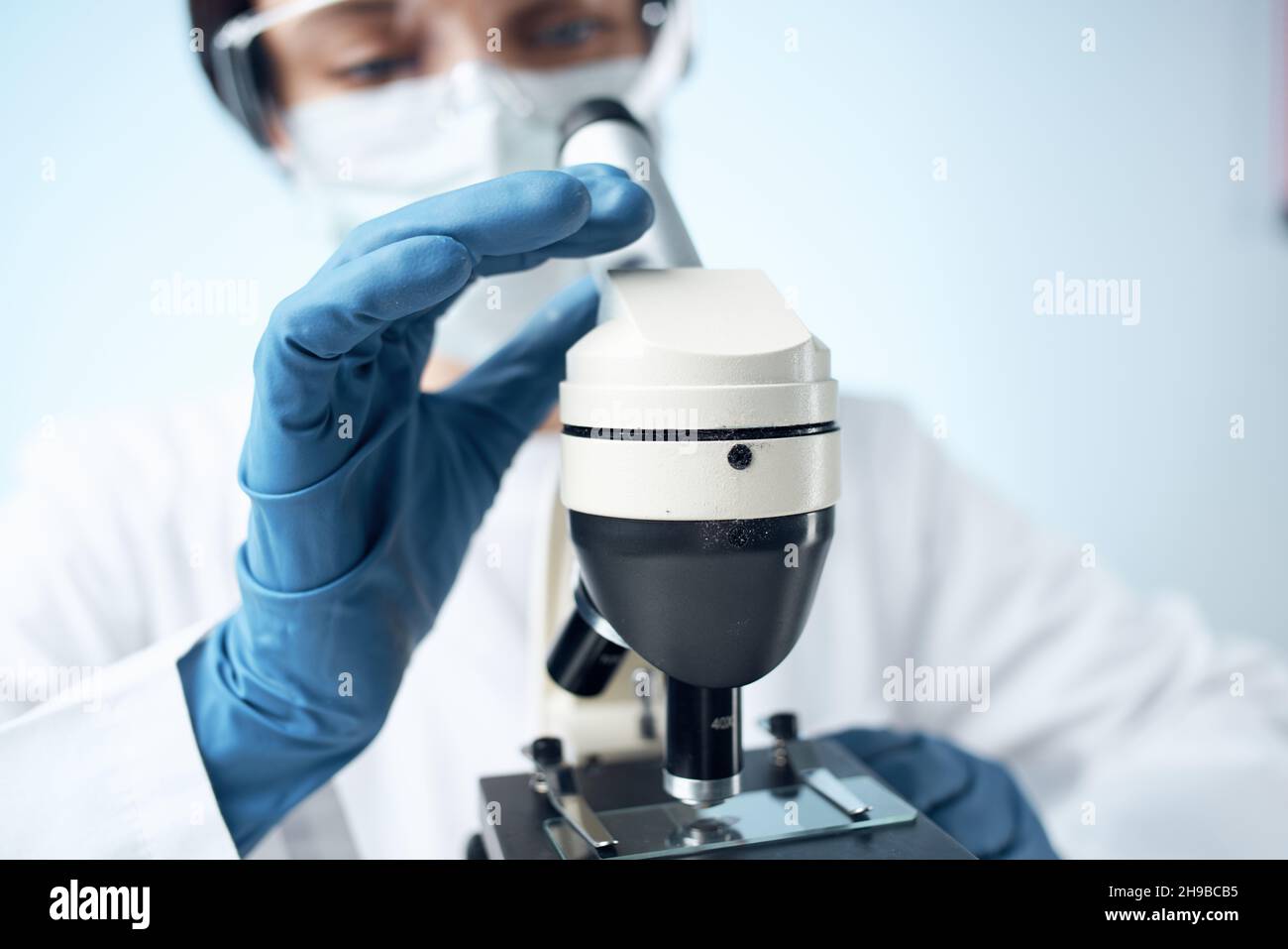 female doctor sitting at the table microscope research biotechnology ...