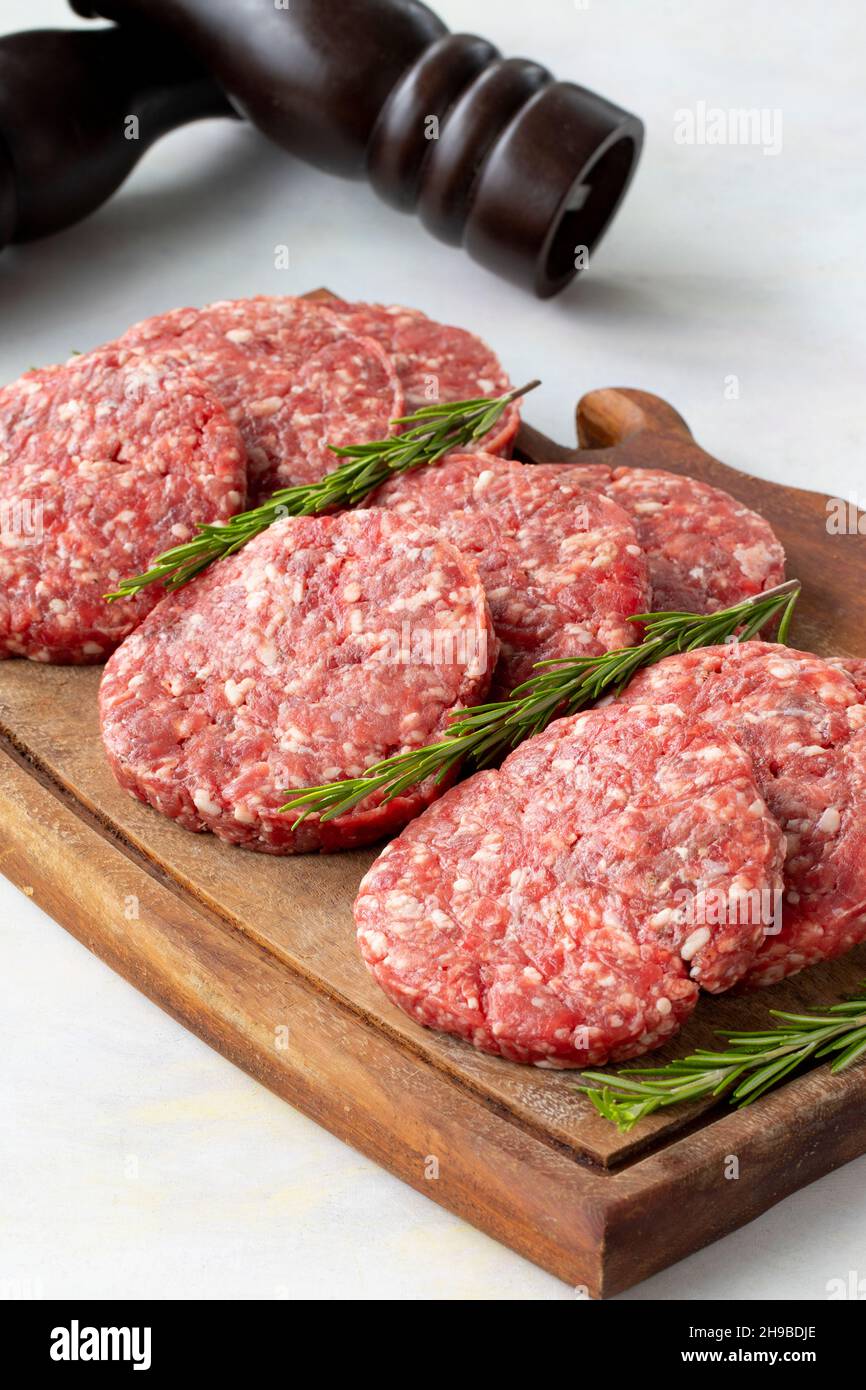 Raw beef burger patties on wooden background Stock Photo - Alamy