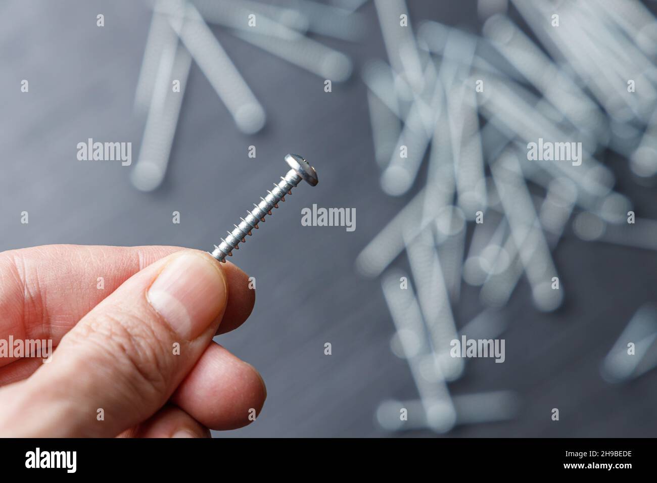 Hand holding one steel screw on a black and white background Stock ...