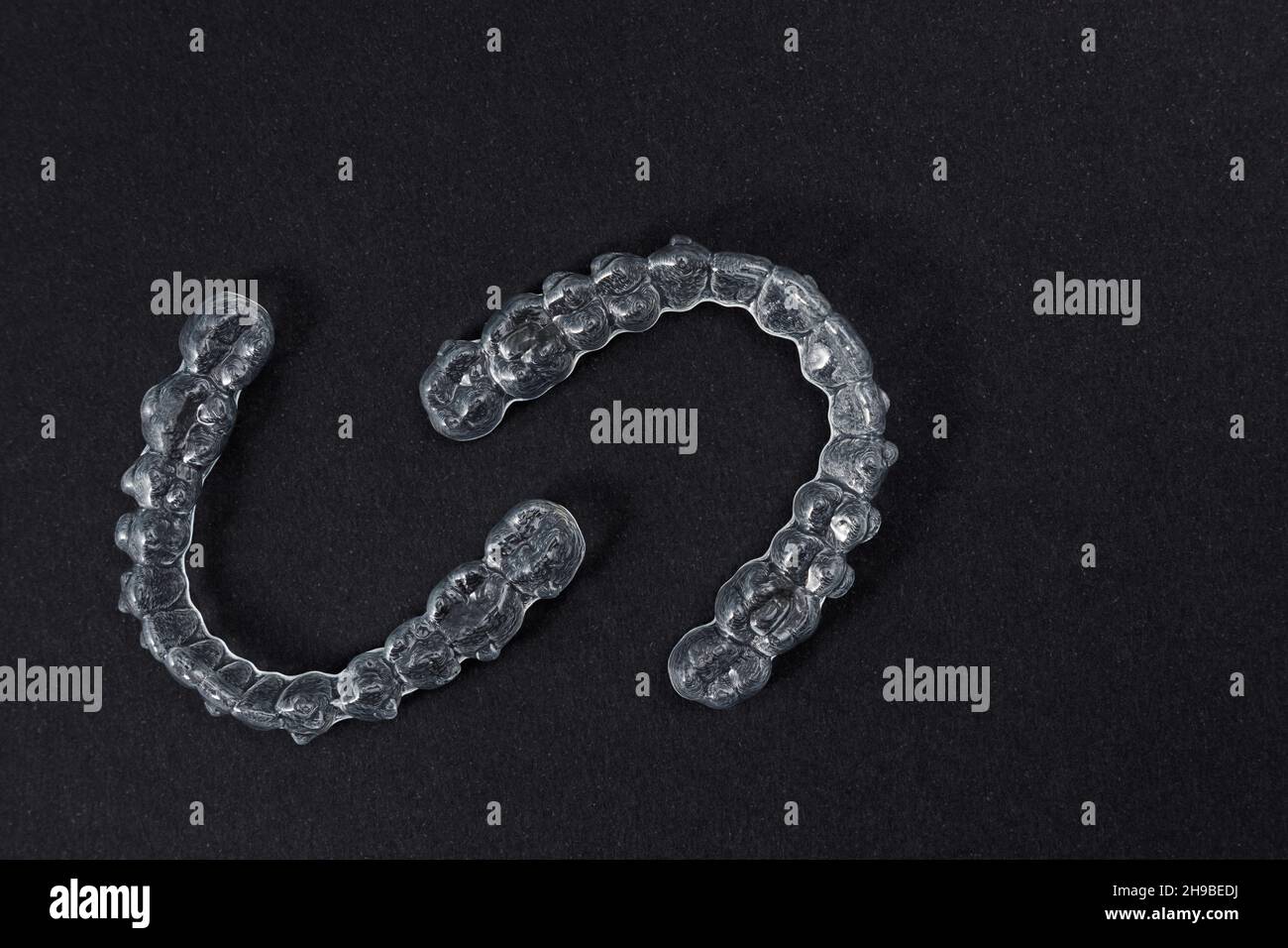 Two transparent retainers on black background. Invisalign orthodontics ...