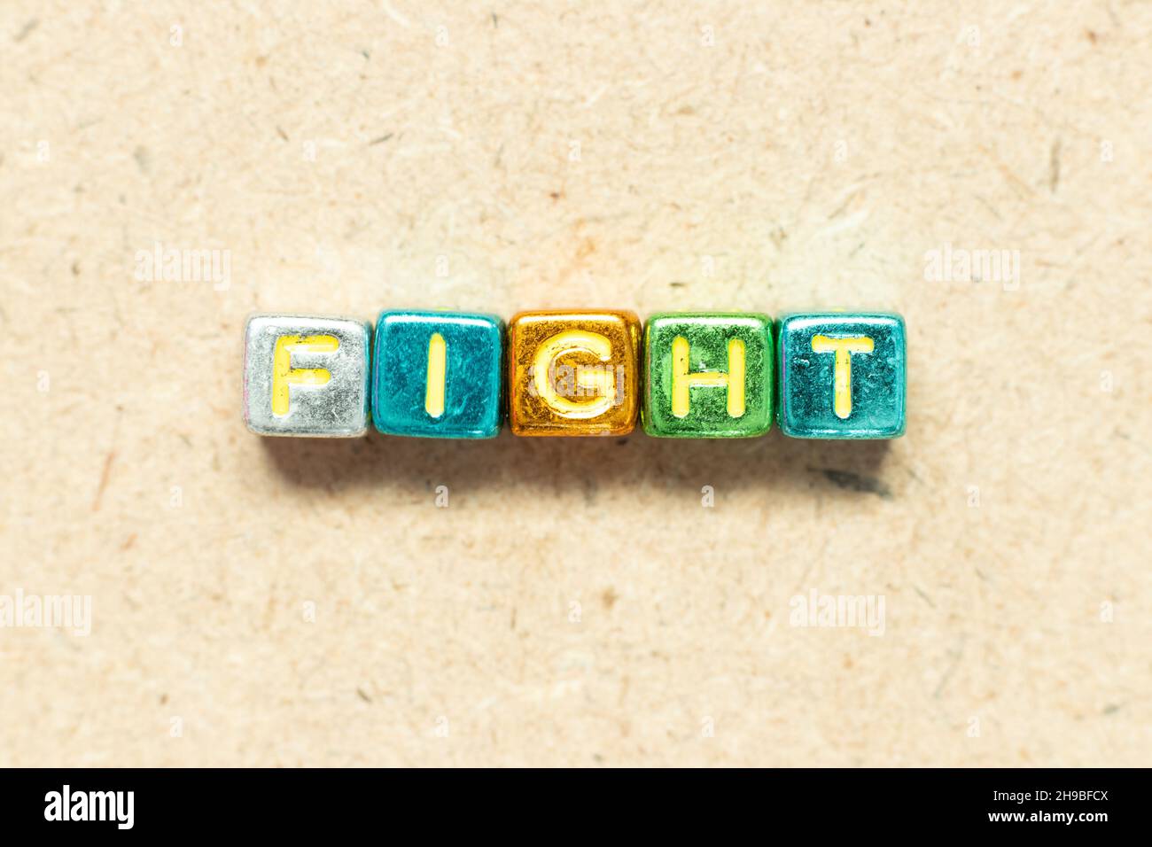 Metallic color alphabet letter block in word fight on wood background ...