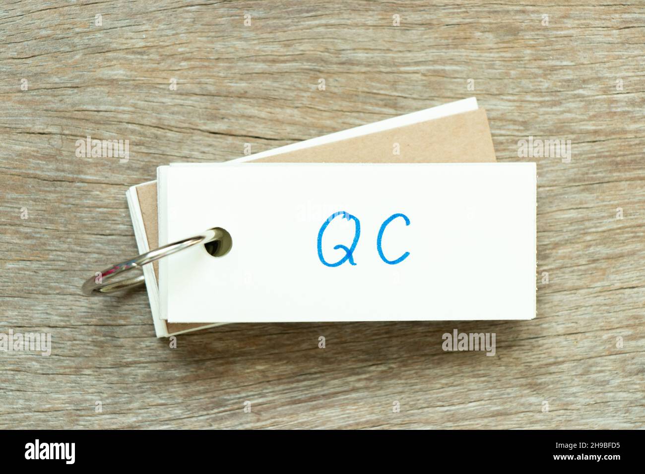 Flash card with handwriting word QC (Abbreviation of Quality Control ...