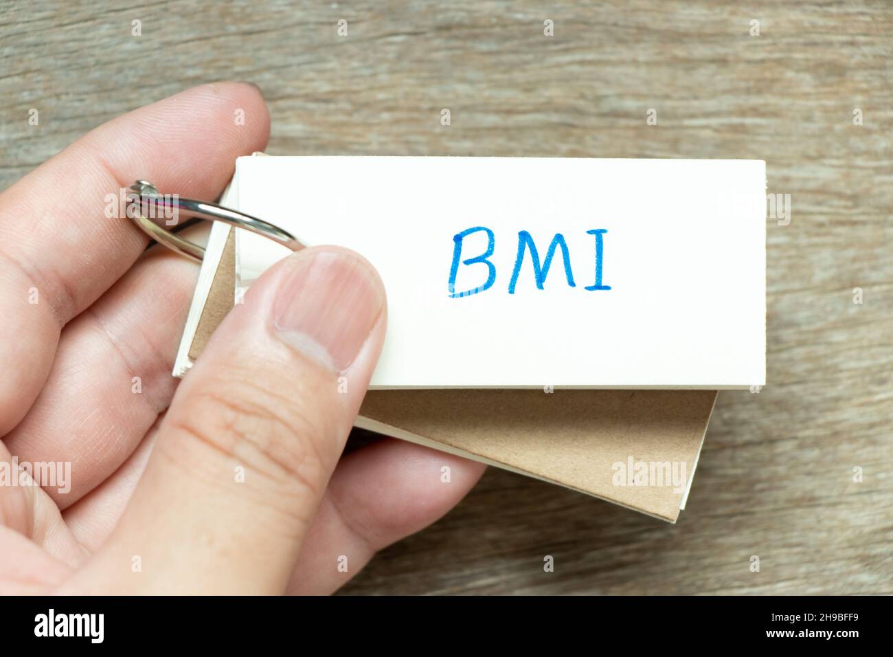 Man hold the flash card with handwriting word BMI (abbreviation of body ...