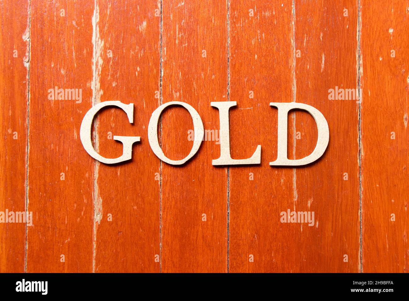 Alphabet letter in word gold on old red color wood plate background ...