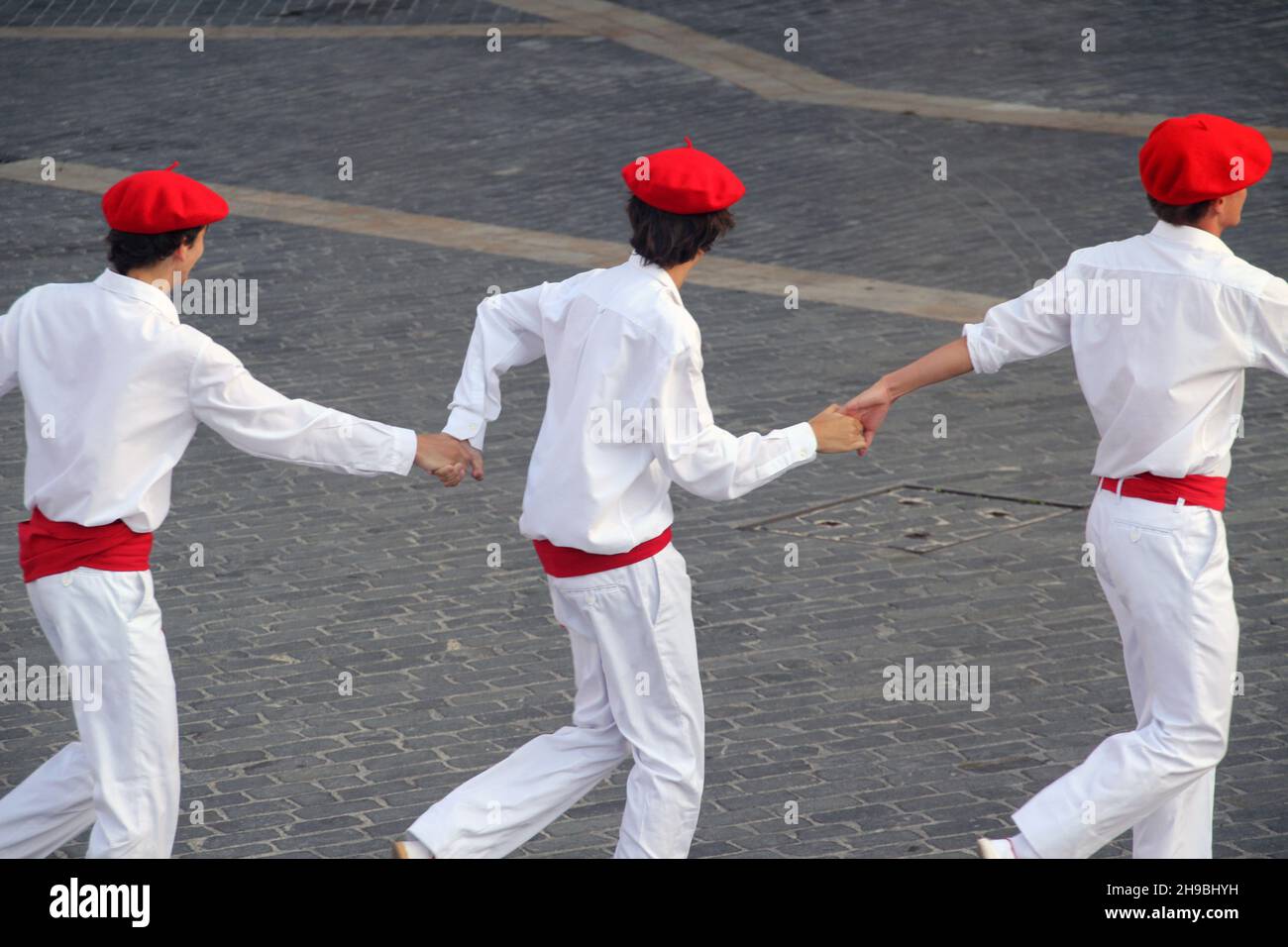 Young males in red berets performing folk dances in Basque Country ...